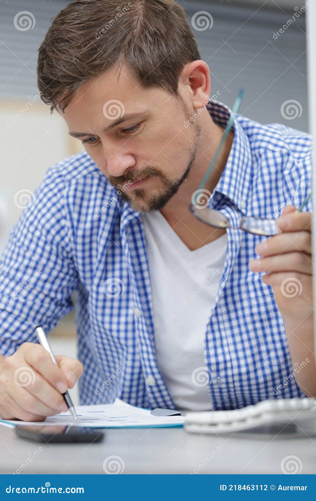 Serious Young Man Making Notes while Working with Documents Stock Photo ...