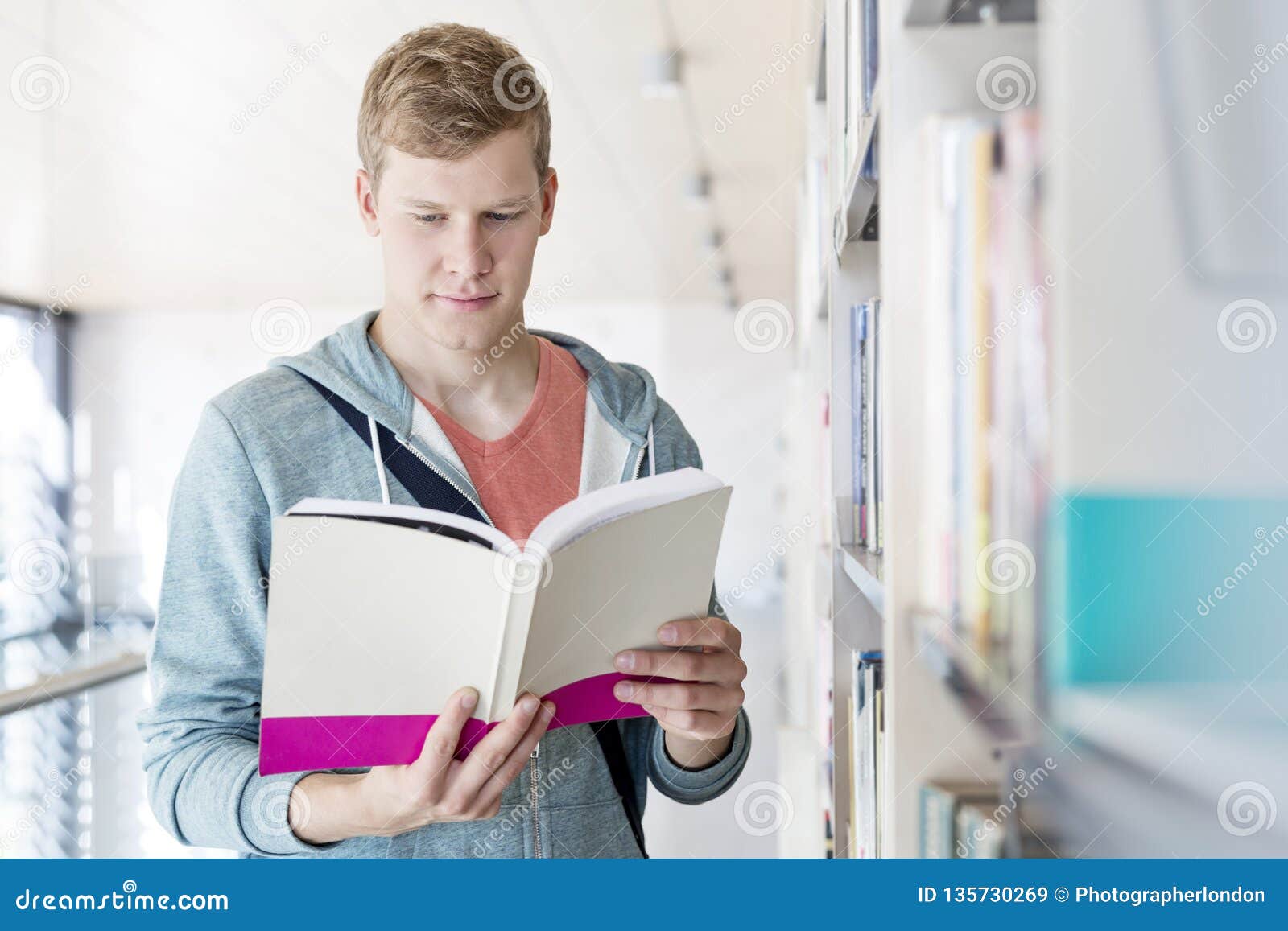 Serious Young Man Reading Book at University Library Stock Image ...