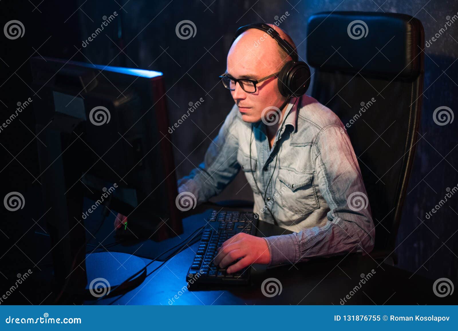 Serious Young Man Sitting and Working with Computer in Dark Office ...