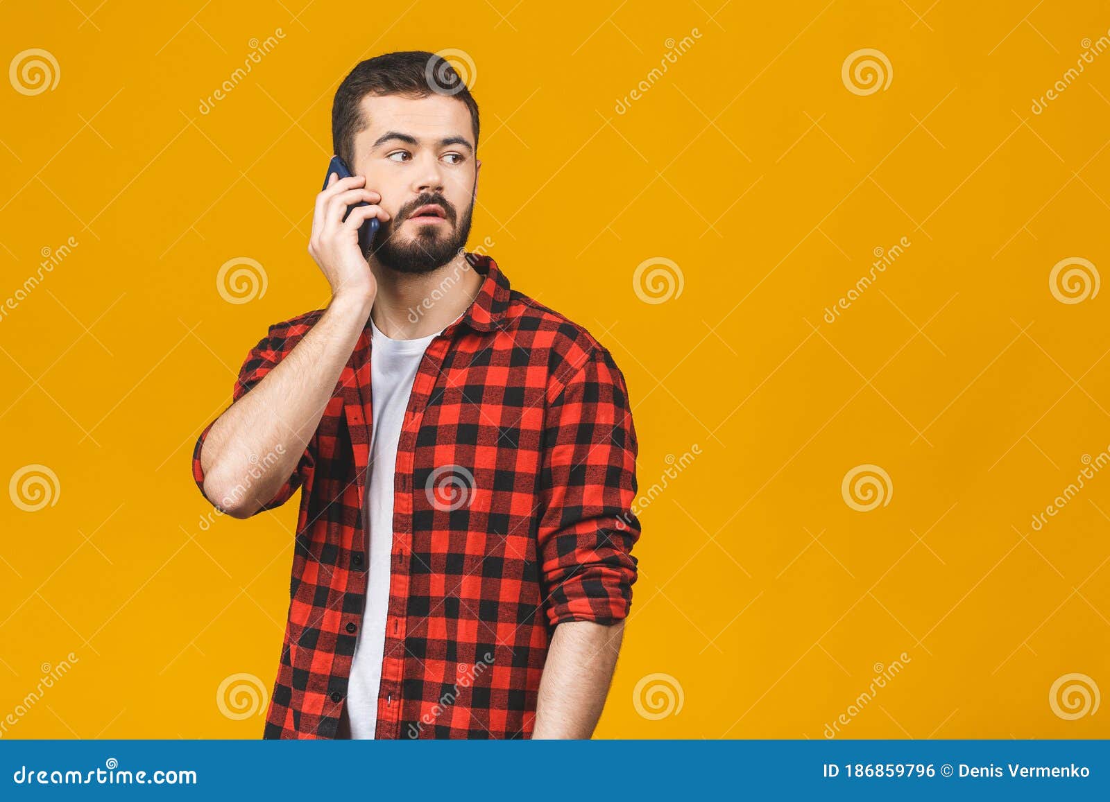 Serious Young Man Talking on Mobile Isolated on Yellow Background Stock ...