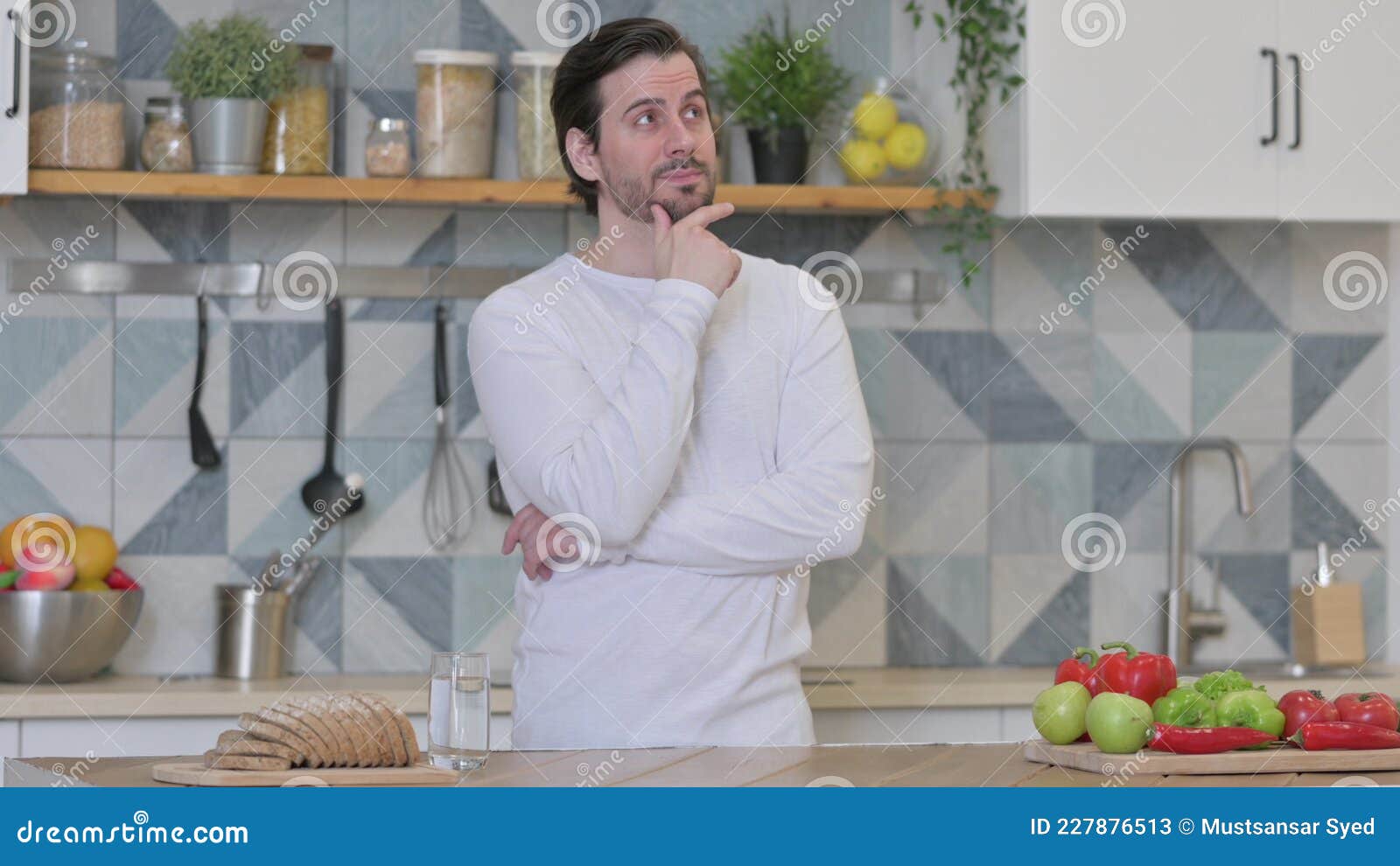 Serious Young Man Thinking while Standing in Kitchen Stock Image ...