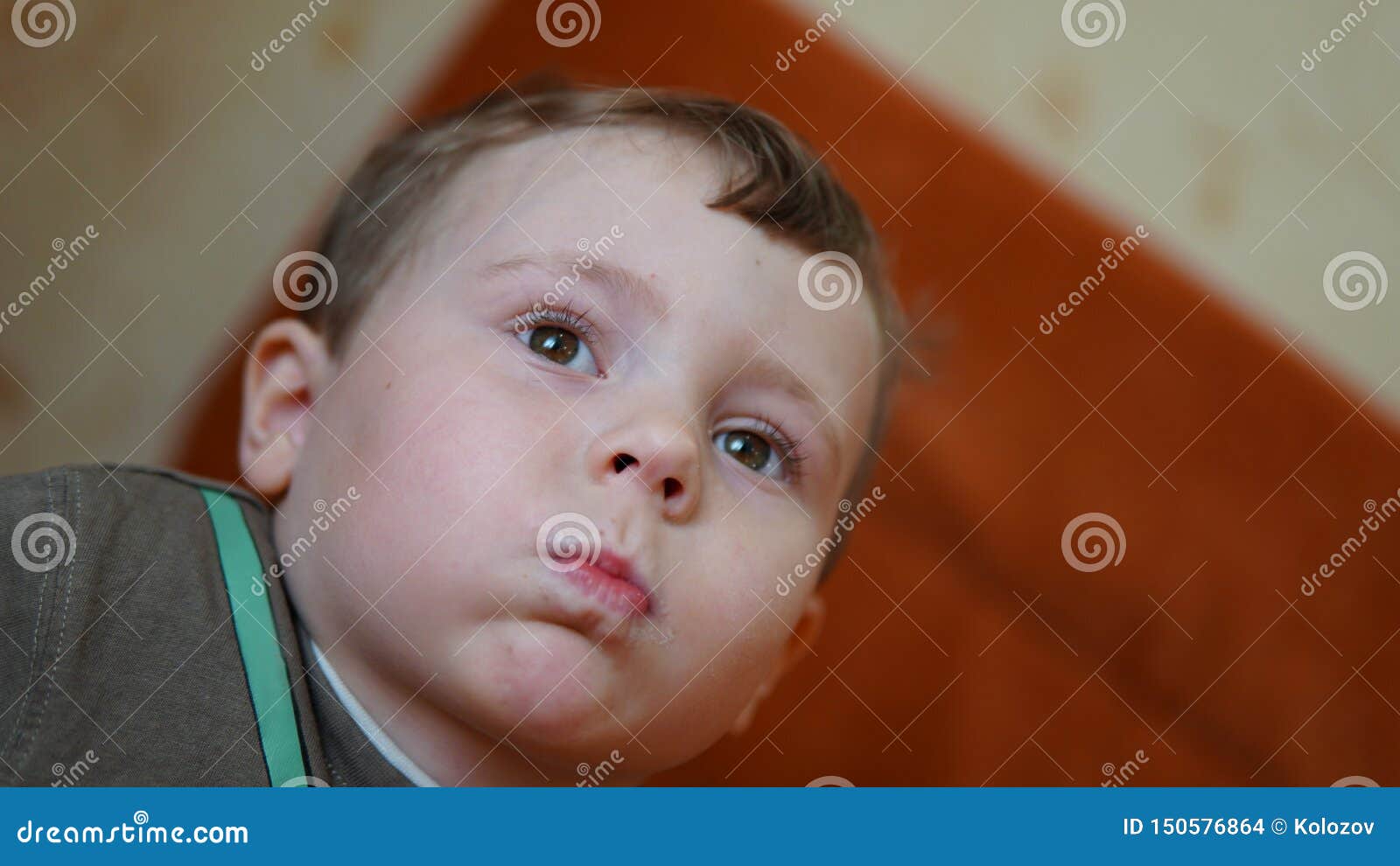 Seriuos Kid Portrait with Inflated Cheeks and Red Background Behind ...