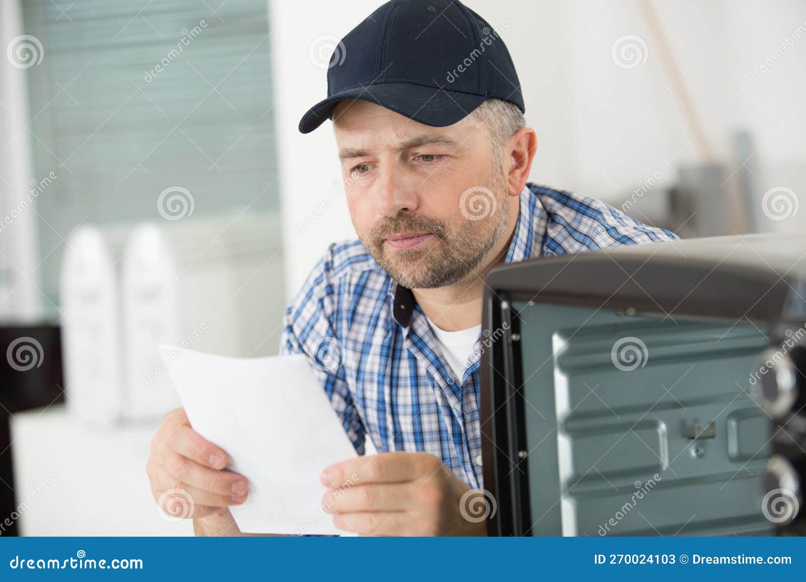 Serviceman Reading Installation Instructions for Appliance Stock Image ...
