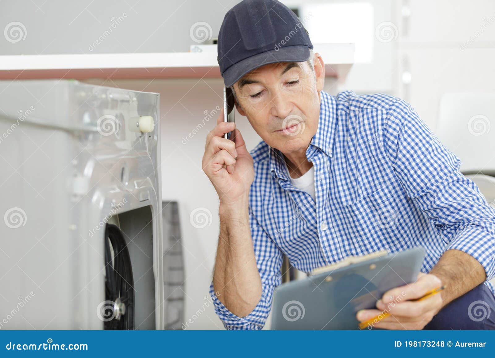 Serviceman by Washing Machine Making Telephone Call Stock Photo - Image ...