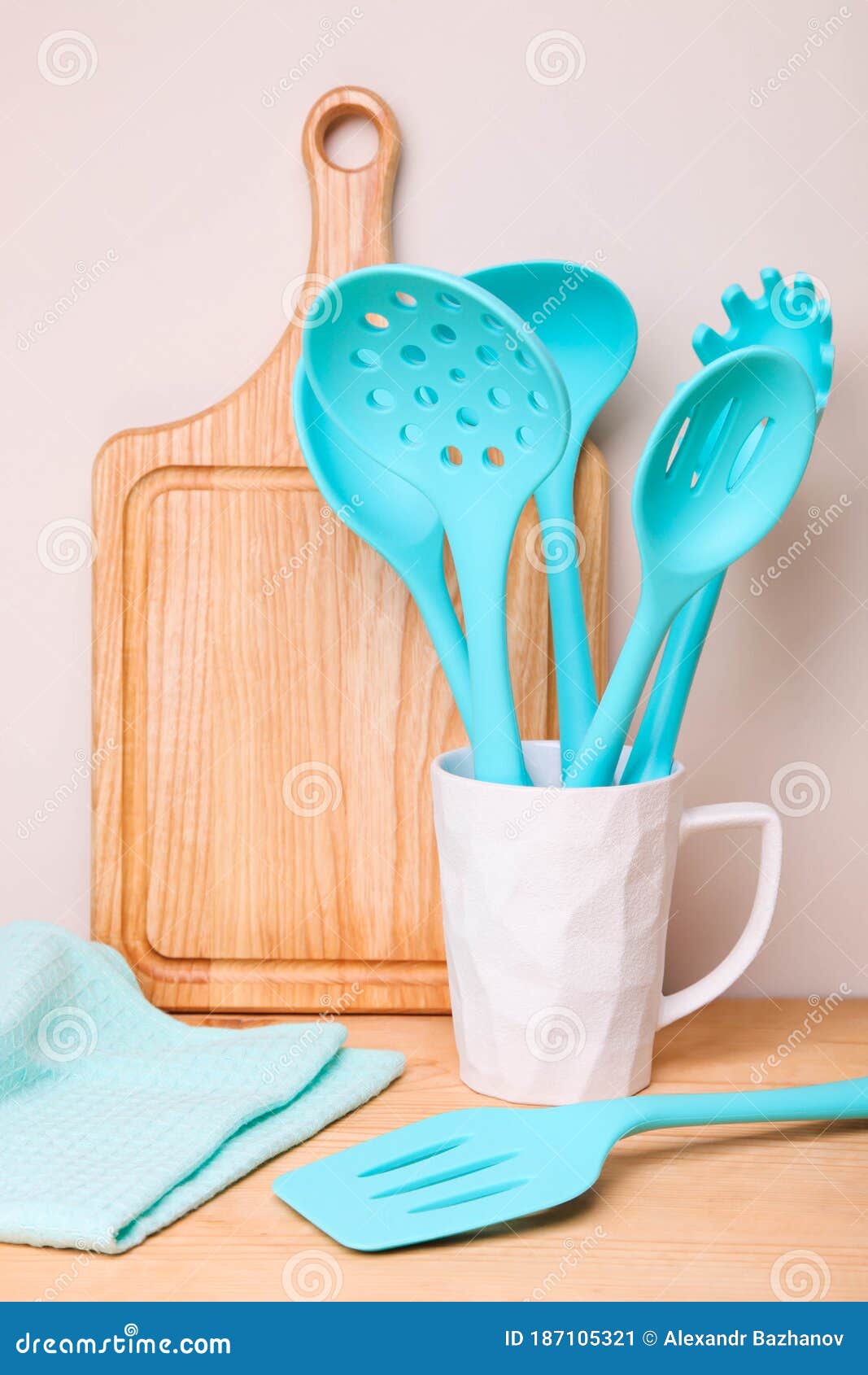 Set of Blue Kitchen Utensils in a Ceramic Cup and Cutting Board Stock ...