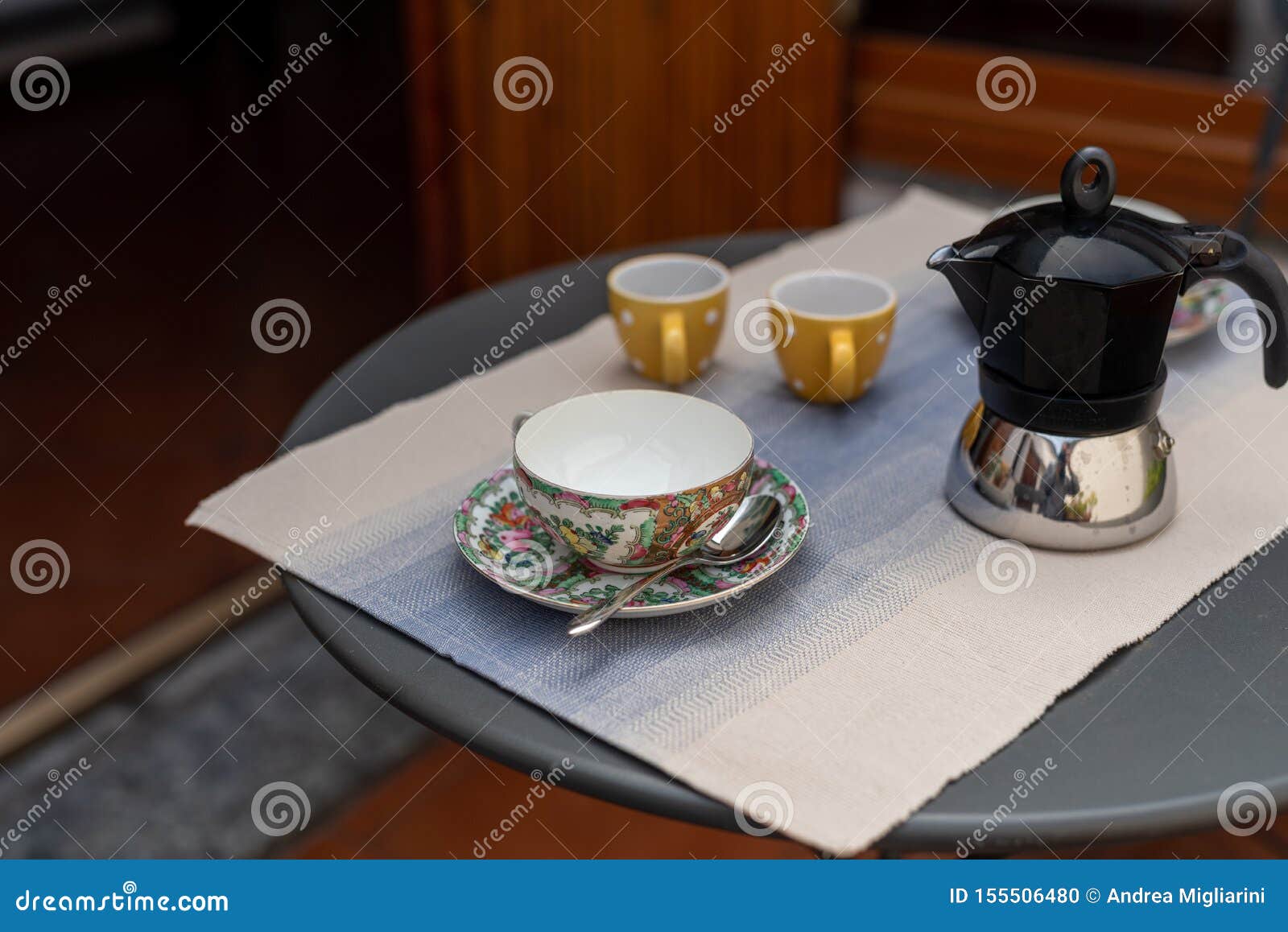 A Set of Decorated Coffee Cups with Coffemaker, on a Table Set for ...
