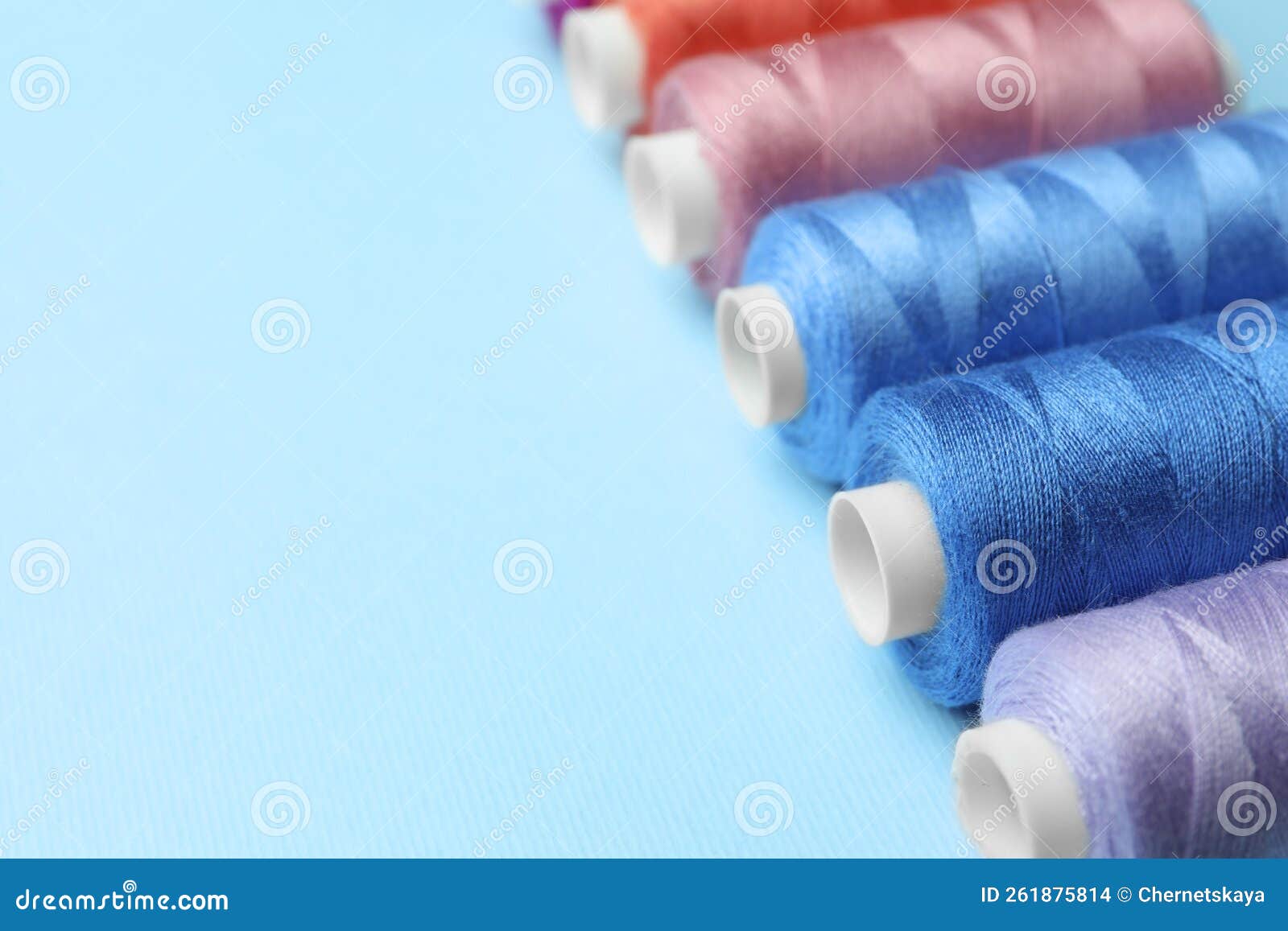 Set of Different Colorful Sewing Threads on Light Blue Background ...