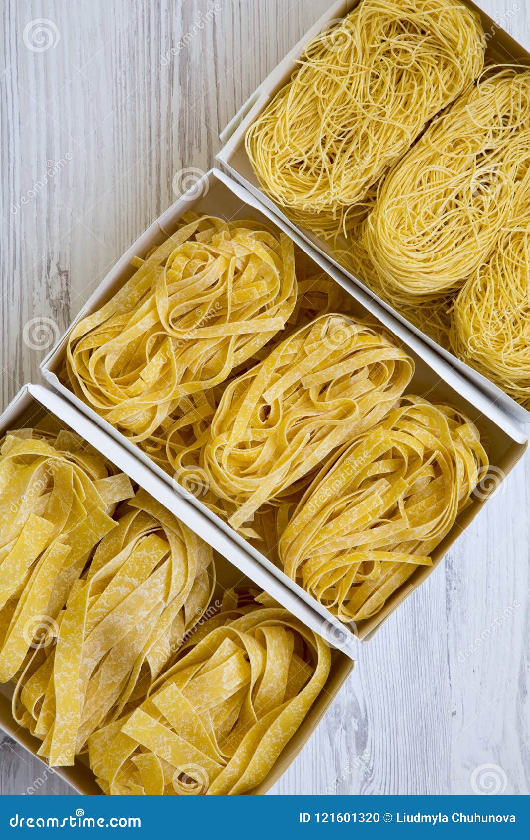 Set of Different Uncooked Pasta in Paper Boxes on a White Wooden Table ...