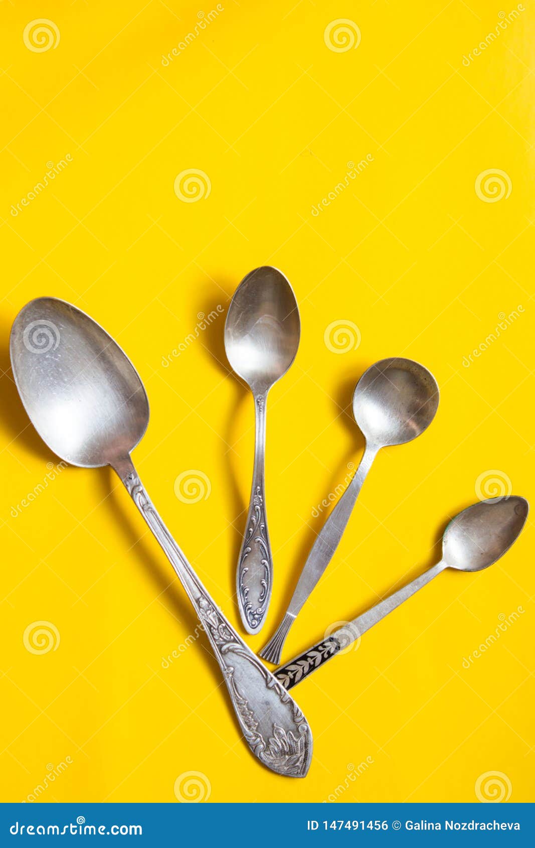 Set of Metallic Vintage Spoons on Yellow Background. Top View Stock ...