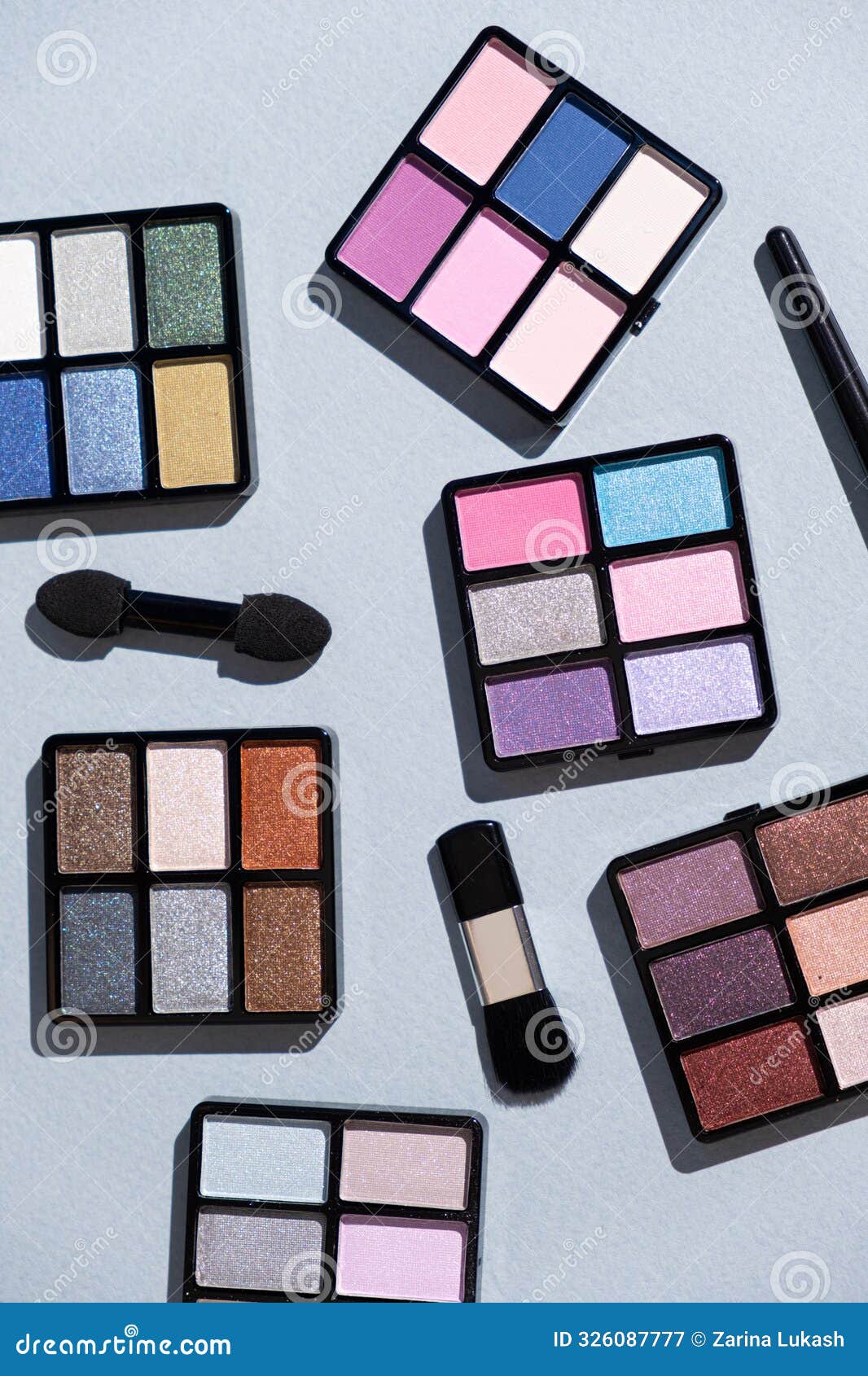 A Set of Multi-colored Eyeshadow and Brushes on a Blue Background. Eye ...