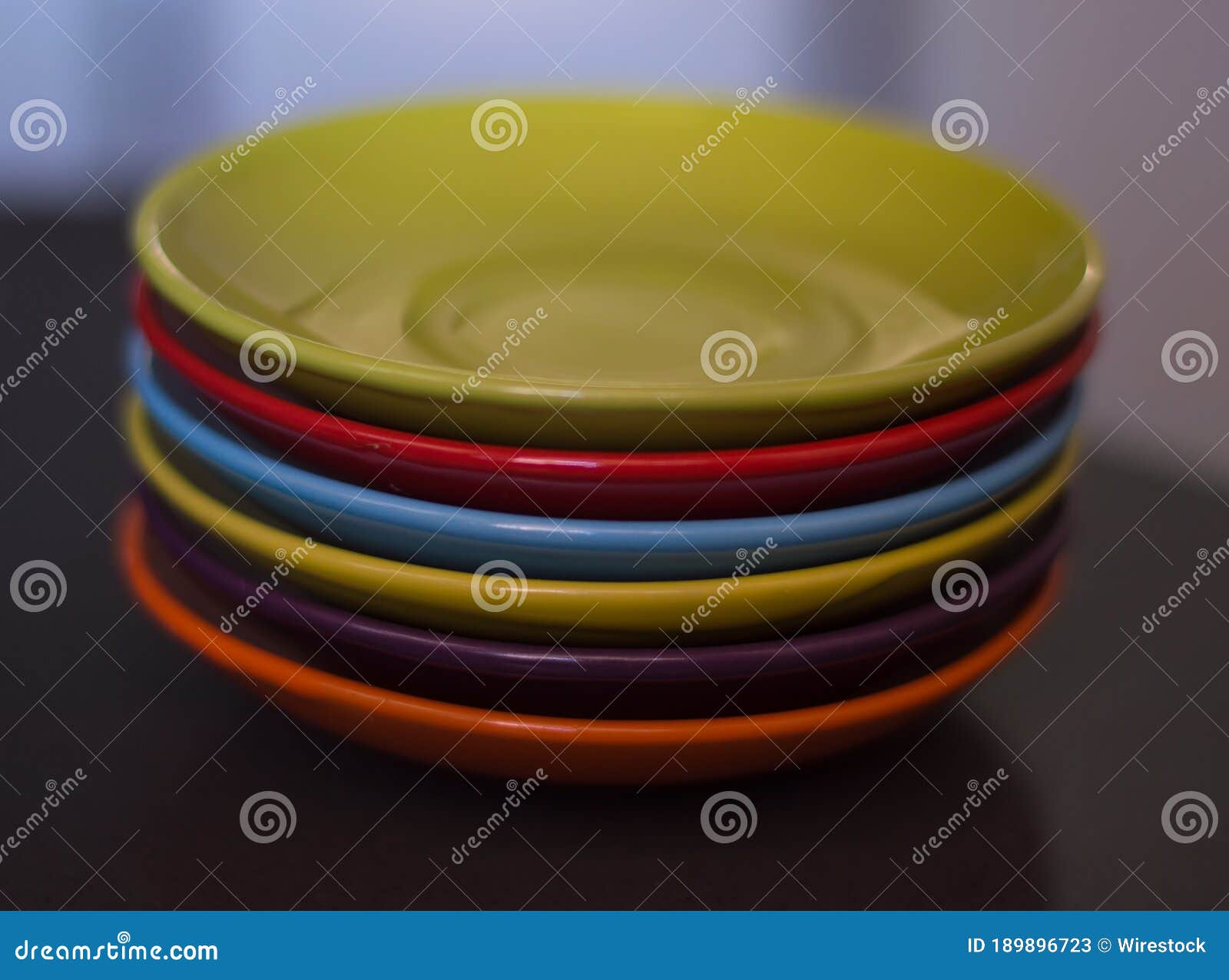 Set of Multi-colored Plates on a Kitchen Table Stock Image - Image of ...