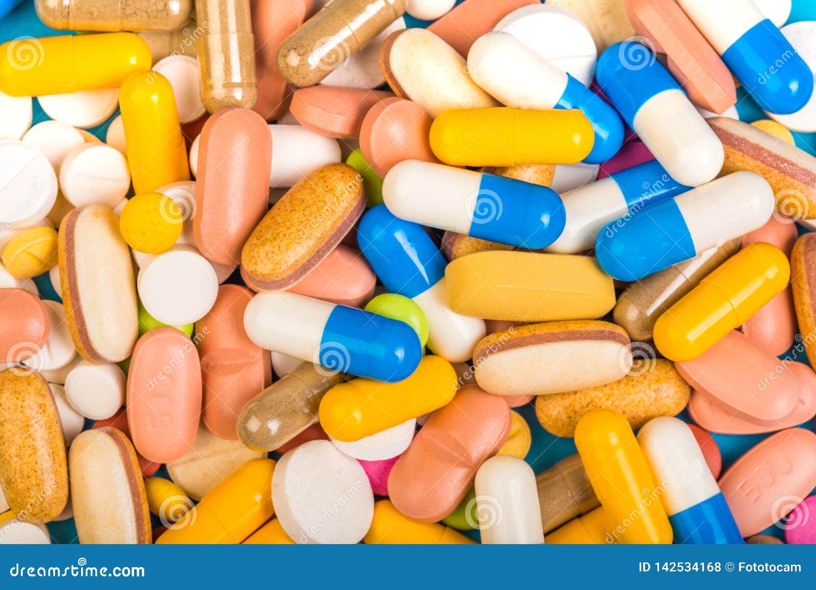 Set of Multi-colored Tablets and Capsules on a Blue Background Stock ...
