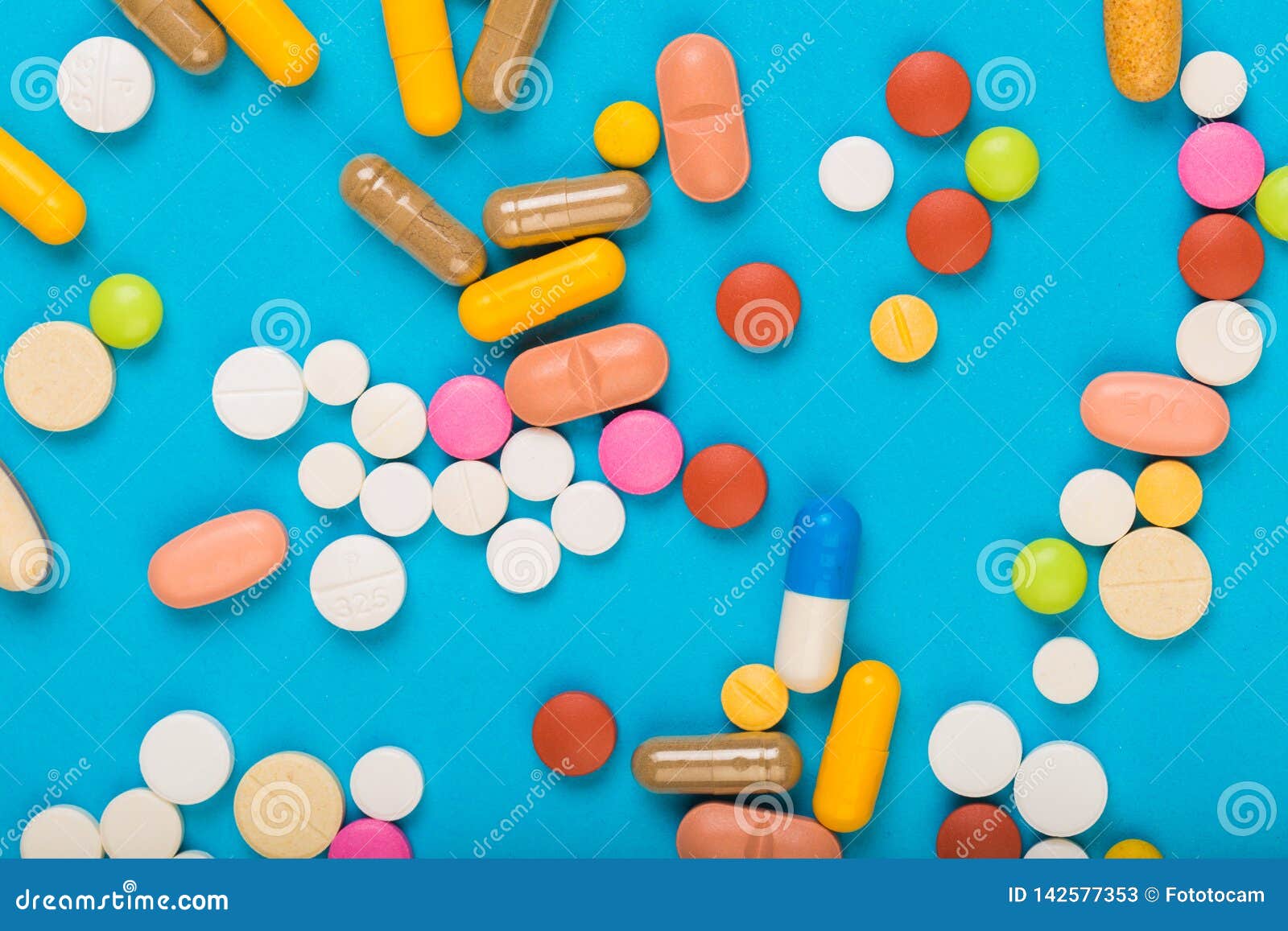 Set of Multi-colored Tablets and Capsules on a Blue Background Stock ...