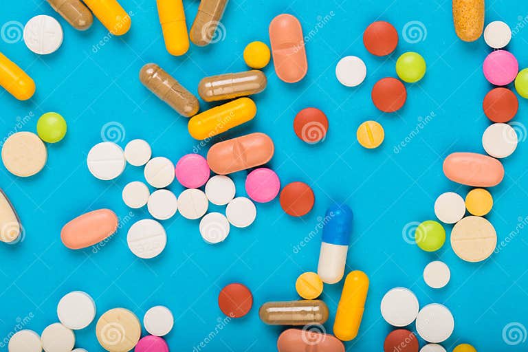 Set of Multi-colored Tablets and Capsules on a Blue Background Stock ...