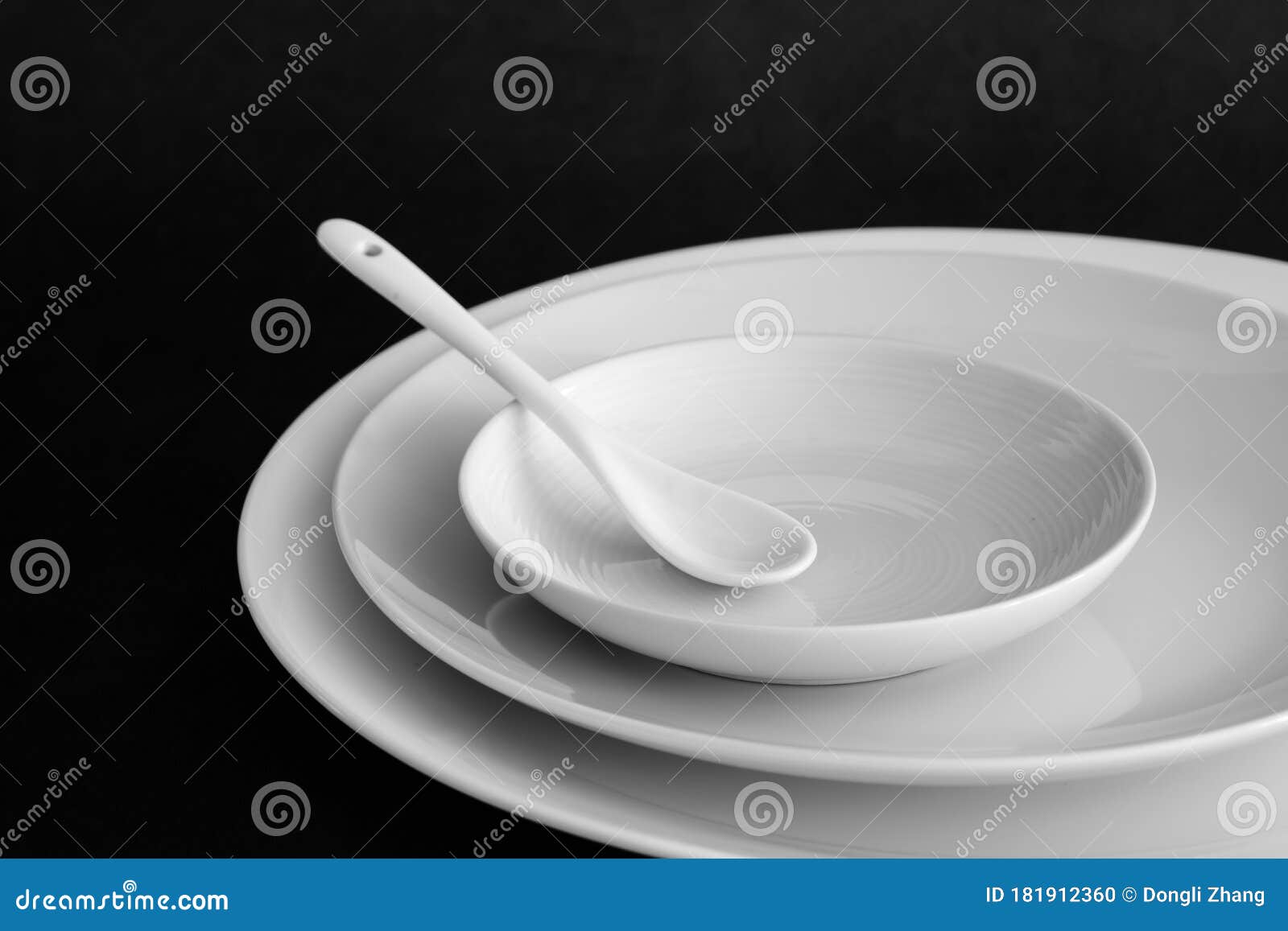 White Color Set of Plates with Spoon on Black Table Stock Photo - Image ...