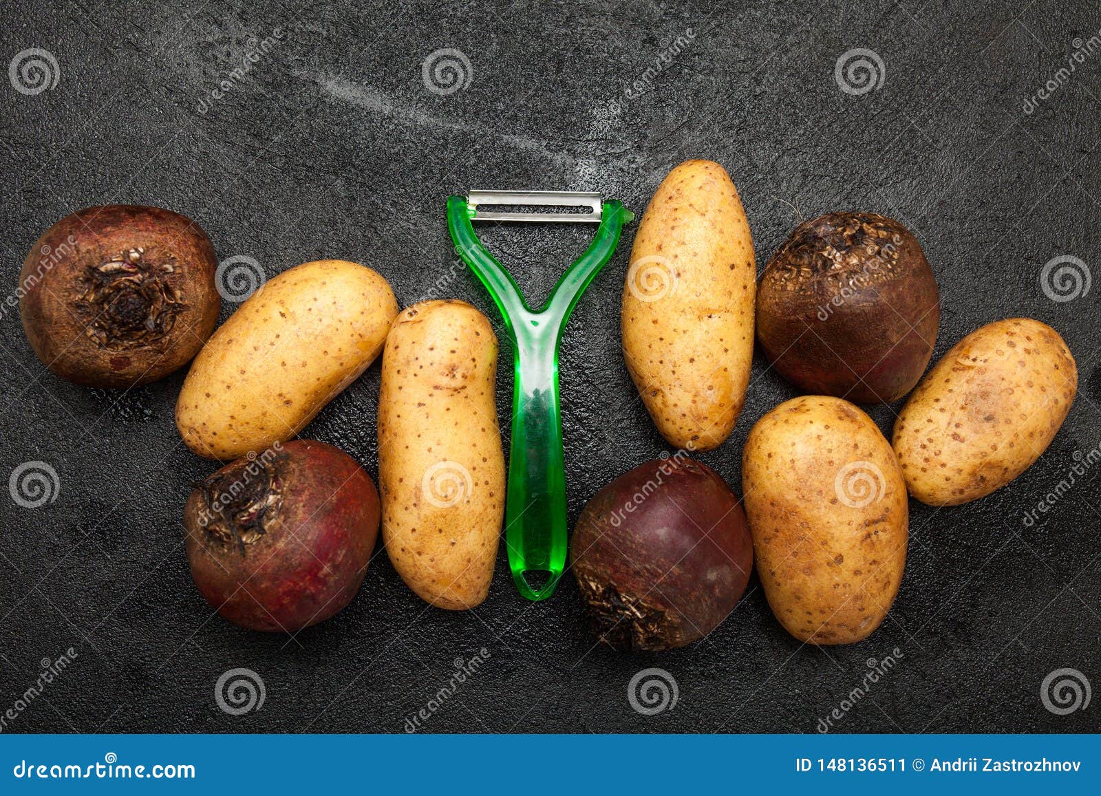 A Set of Potatoes and Red Beet with a Vegetable Grinder on a Black ...