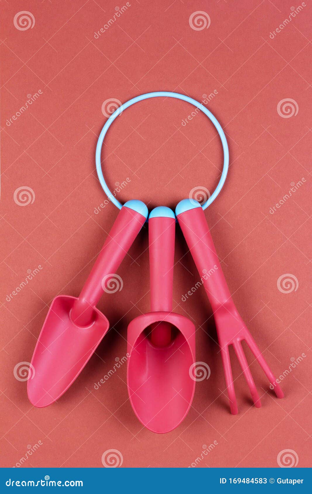 Set of Red Plastic Garden Tools on a Blue Ring on a Brown Background ...