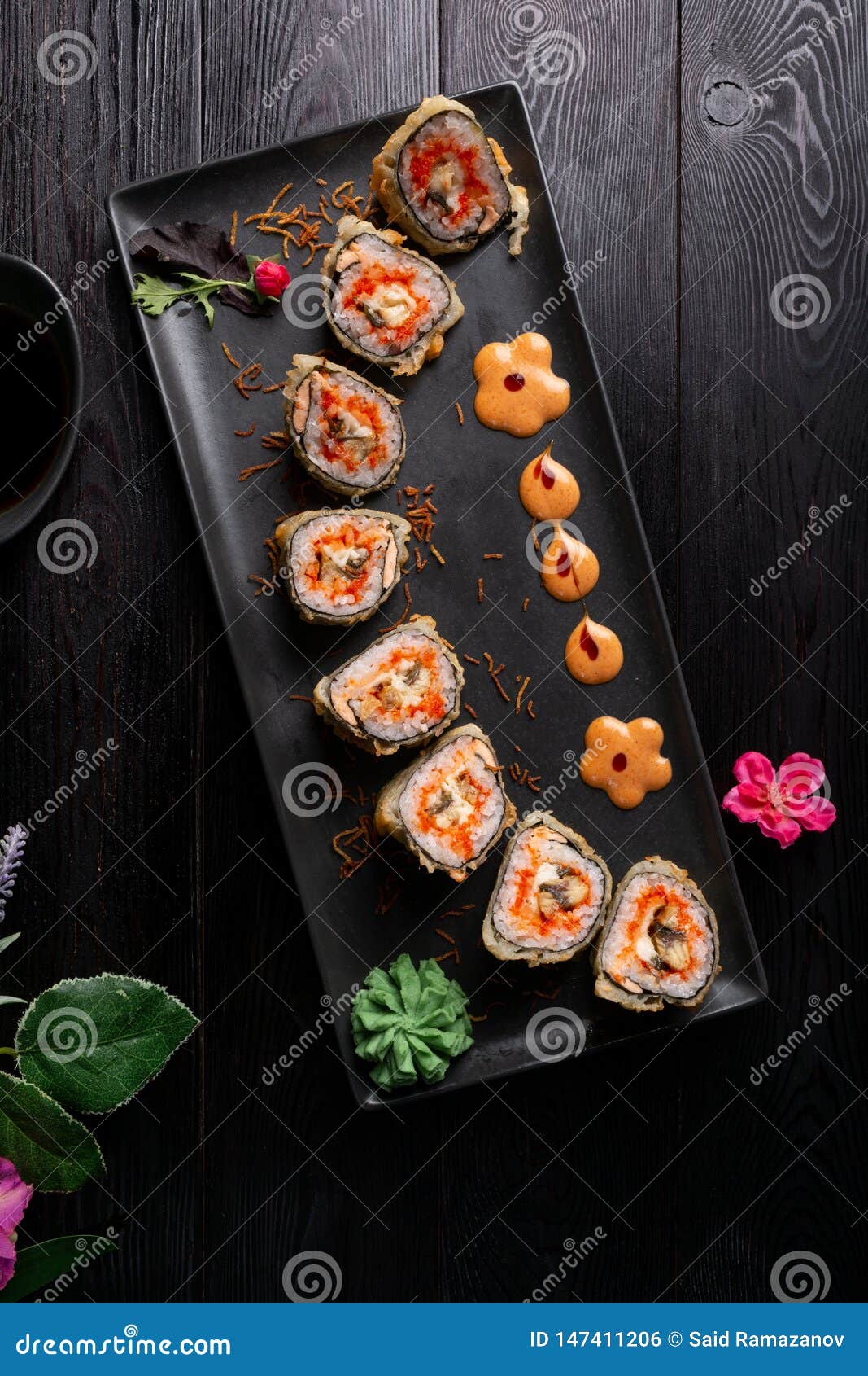 Set Sushi Rolls on a Black Rectangular Plate on a Dark Background Stock ...