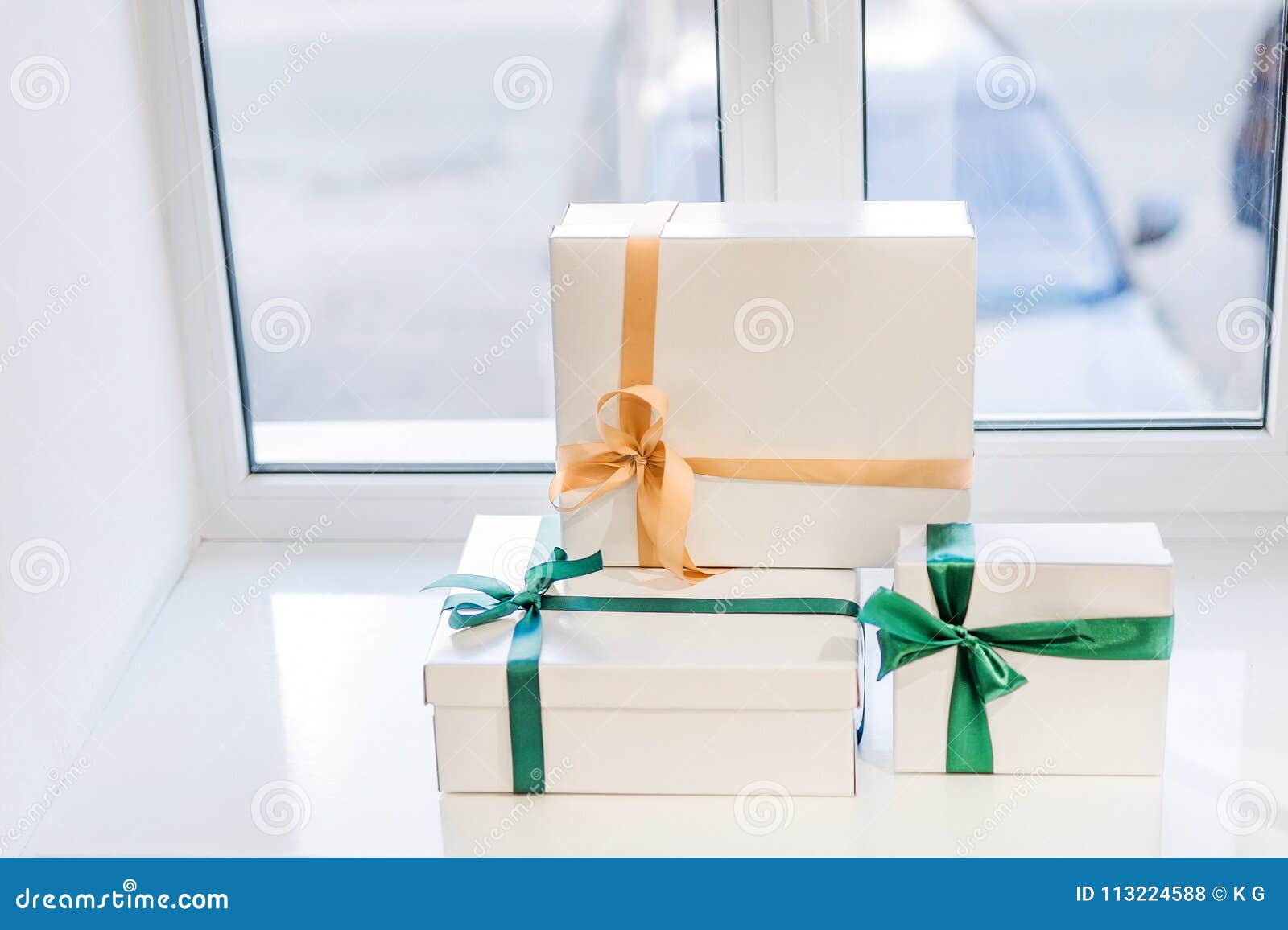 Set of White Gift Boxes with Different Colored Ribbons on Windowsill ...
