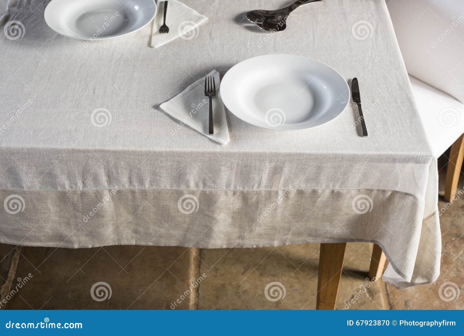 Sets of Dinnerware Arranged on White Linen-Covered Table Stock Photo ...