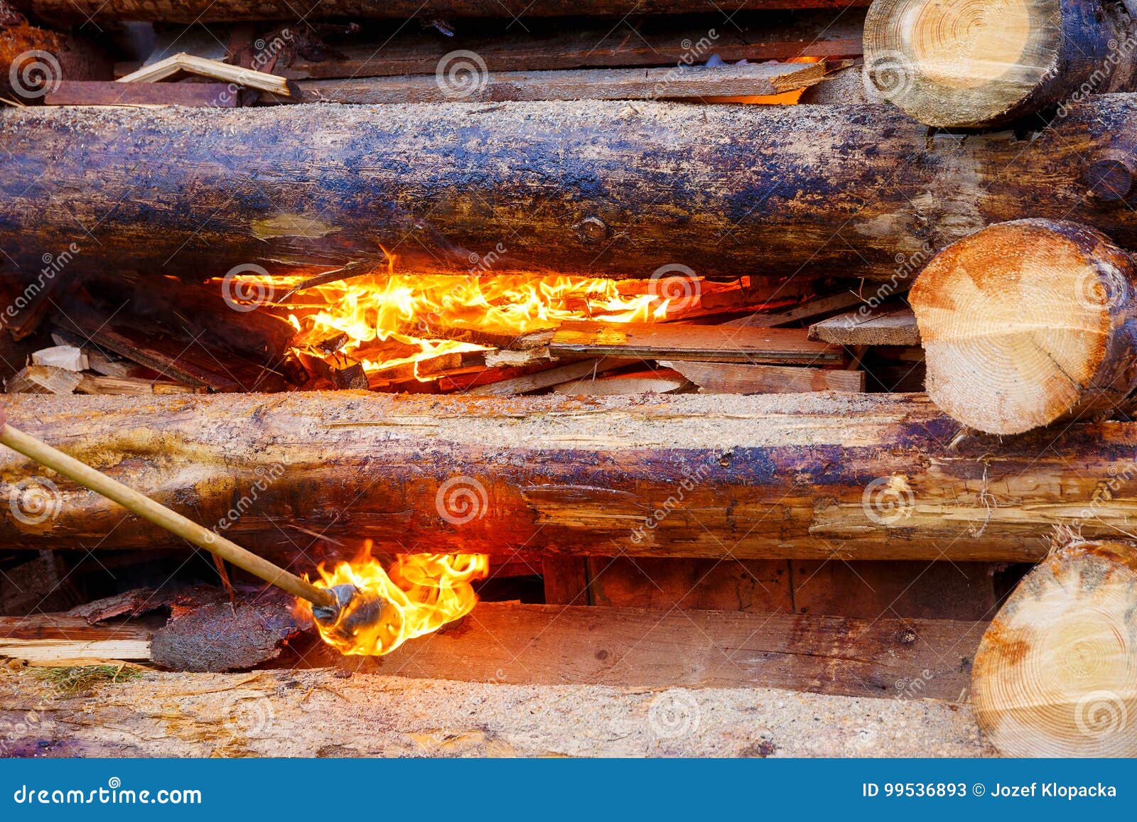 Setting Big Bonfire Made of Logs on Fire with Torch. Stock Image ...