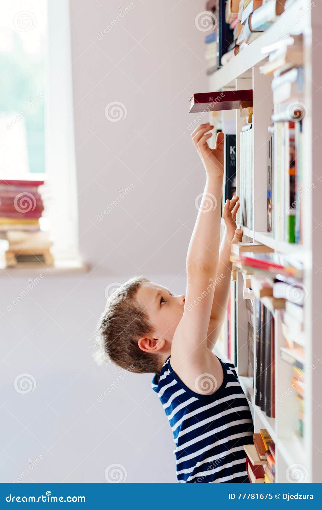 Seven Years Old Boy Reaching for Book in Library. Stock Image - Image ...