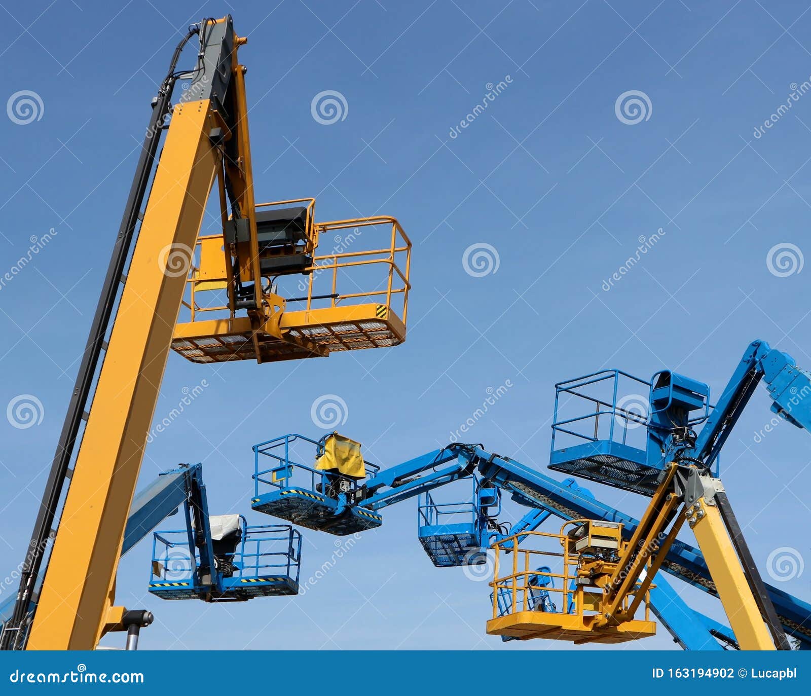 Several Aerial Working Platforms of Cherry Picker Against Blue Sky ...