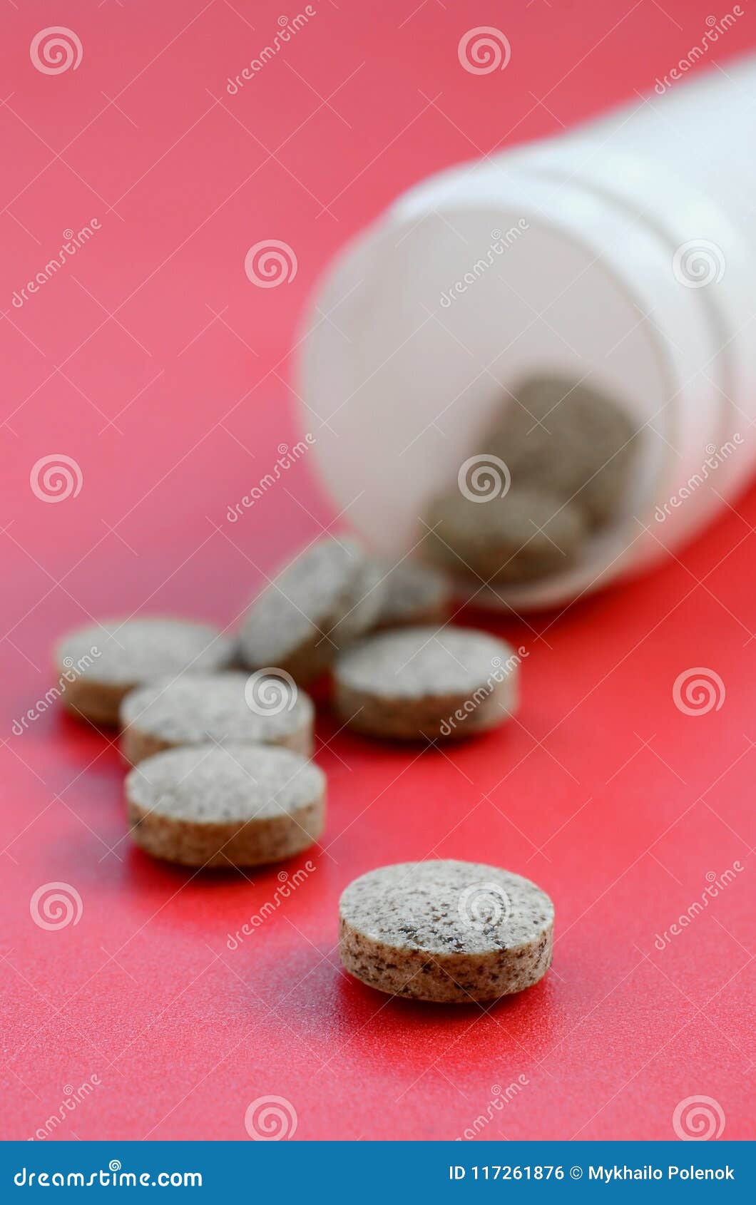 Several Brown Tablets Fall Out of the Plastic Jar on the Red Surface ...