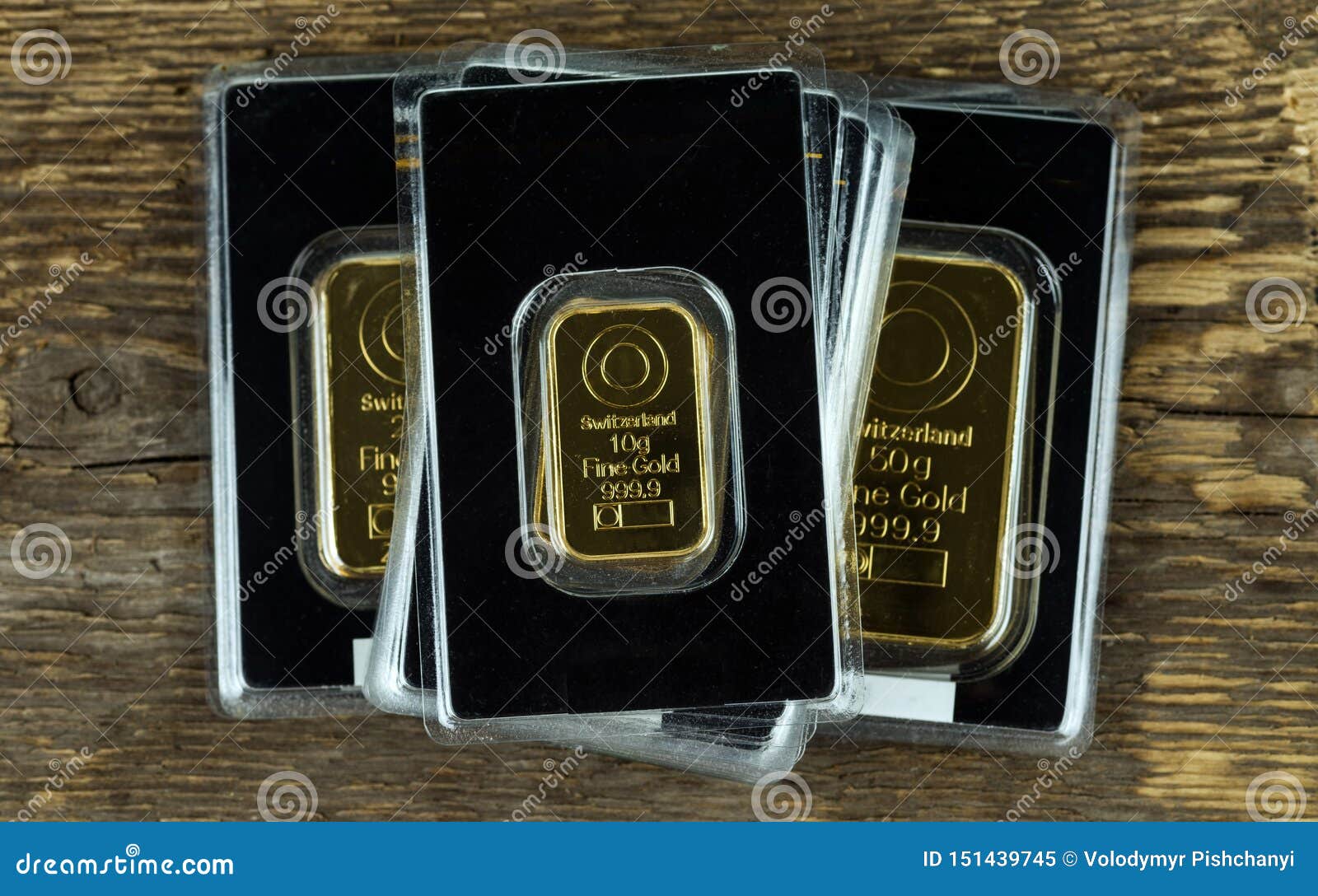 Several Gold Bars of Different Weight in Plastic Packaging on a Wooden ...