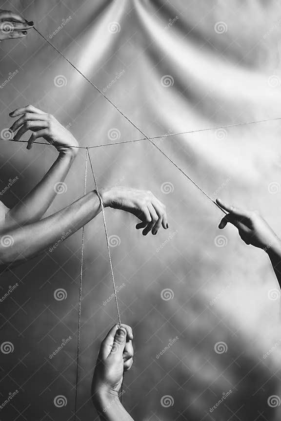 Several Hands Joined and Connected through a Taut Thread. Black and ...