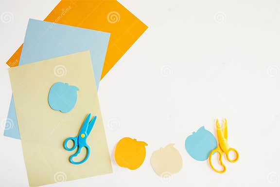 Several Sheets of Colored Paper, Two Scissors, and Apple-shaped Sticky ...