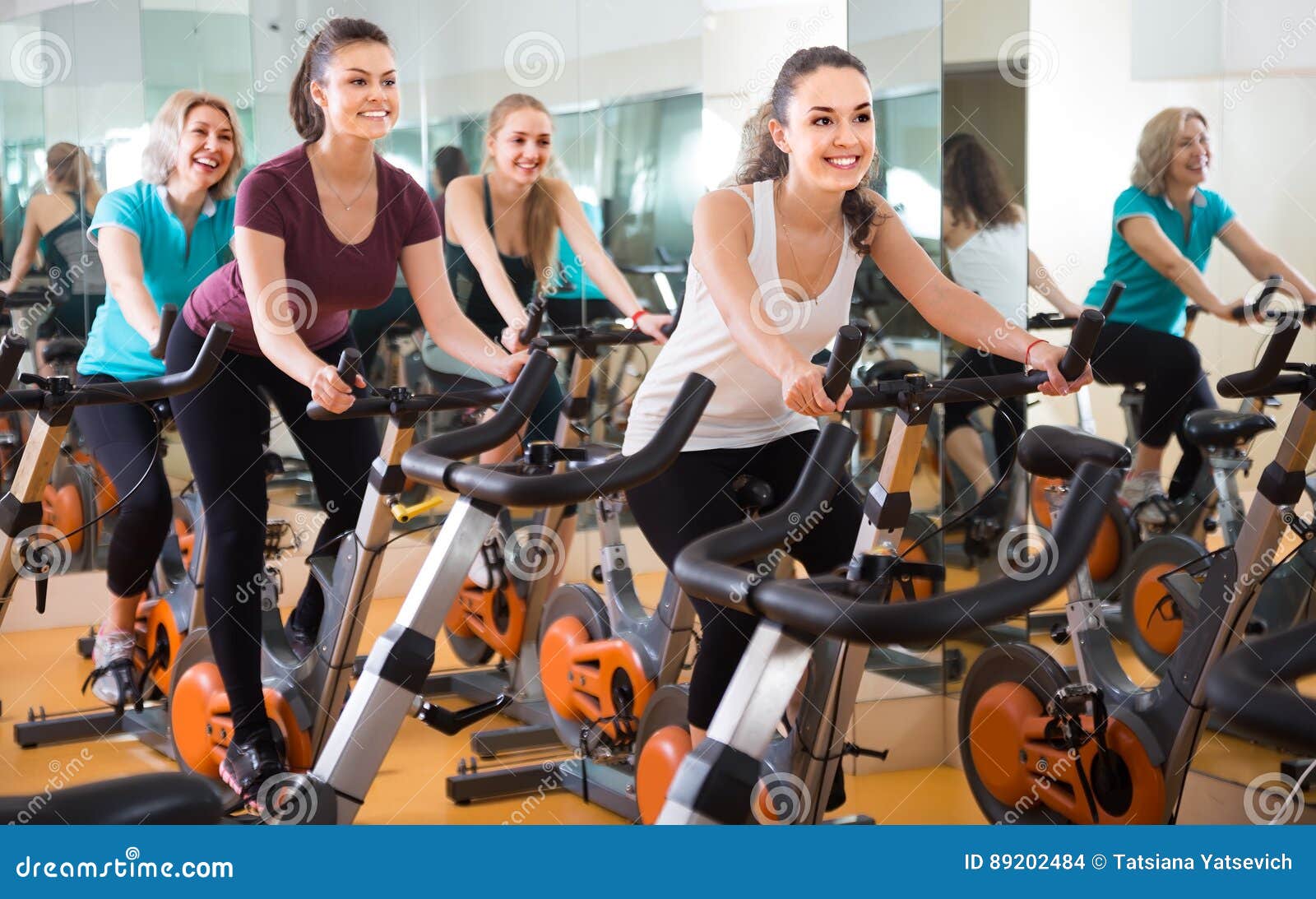 Several Women of Different Age Training on Exercise Bikes Stock Photo ...