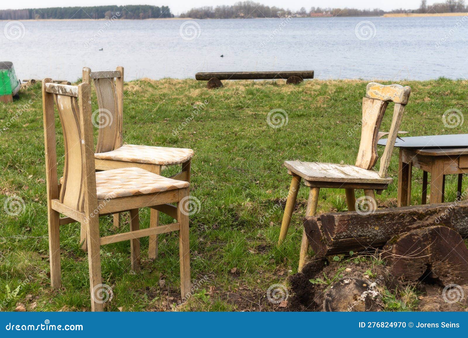 Several Wooden Chairs in the Field by the Lake and Wooden Benches in ...