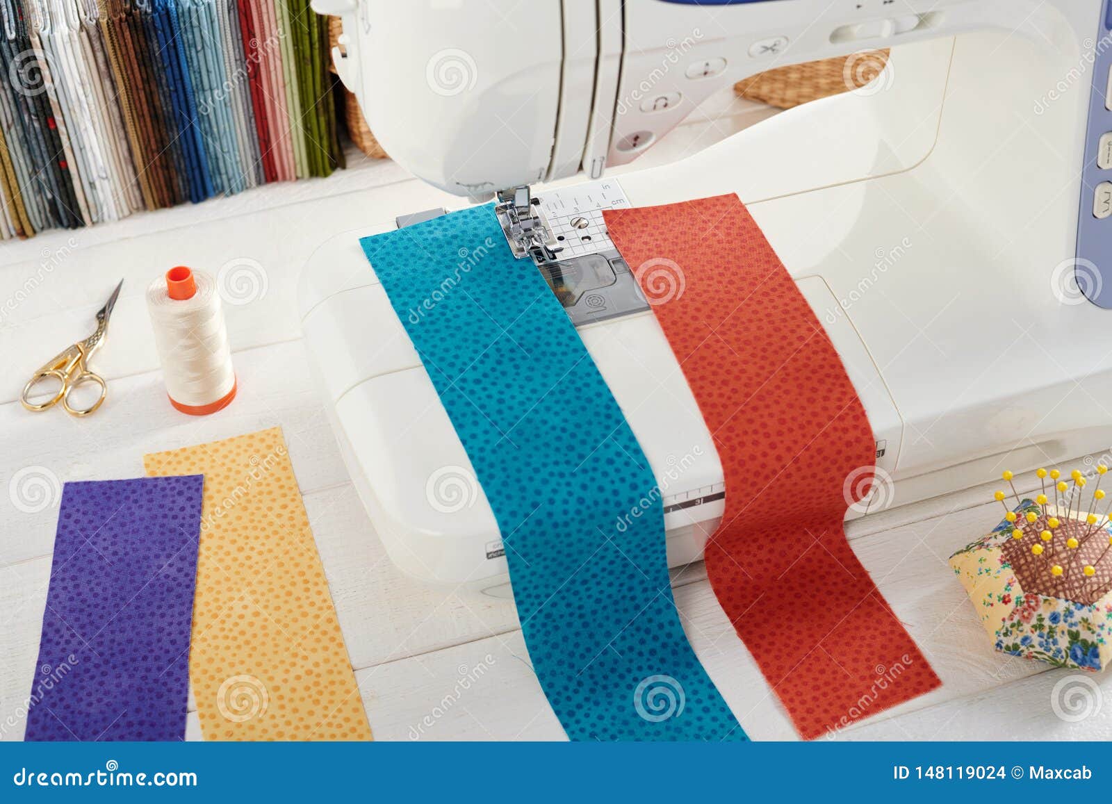 Sewing Machine with a Strips of Fabrics on the Background of Stack of ...