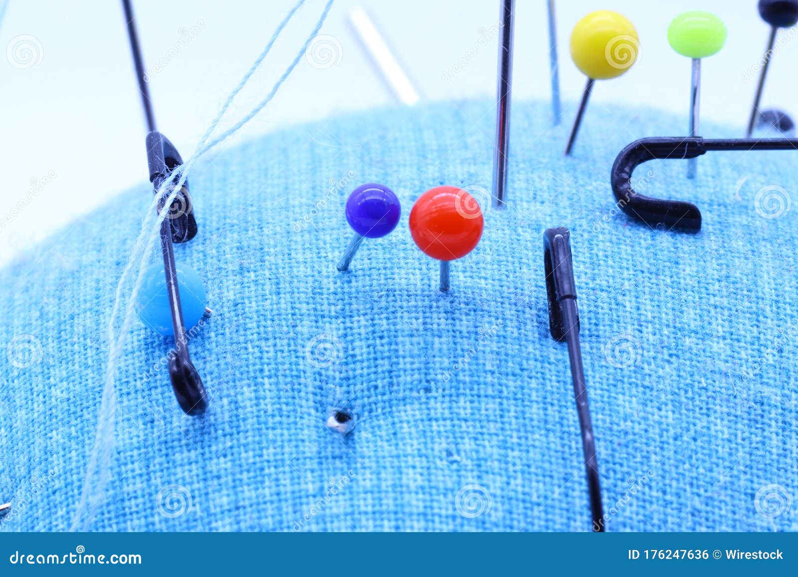 Sewing and Safety Pins Stuck on a Blue Pillow Stock Photo - Image of ...
