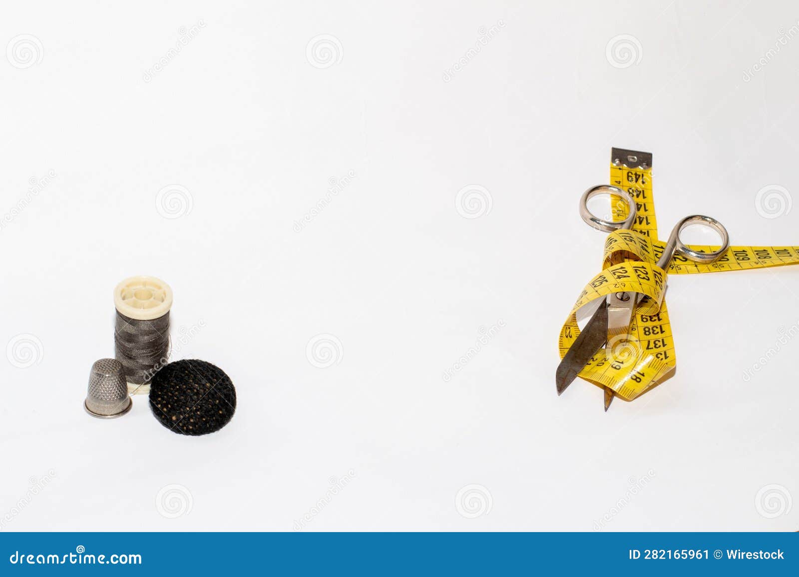 Sewing Scissors, Thread, Thimble and a Tape Measure on a White ...