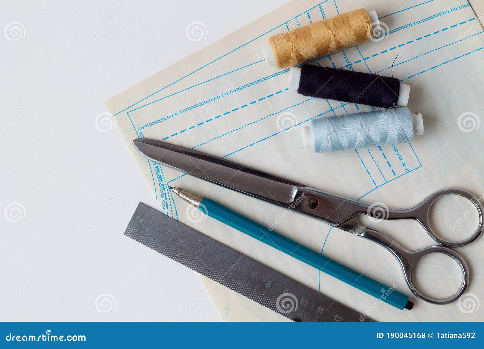 Sewing Thread, Pencils, Ruler, Scissors and Patterns on a White Table ...
