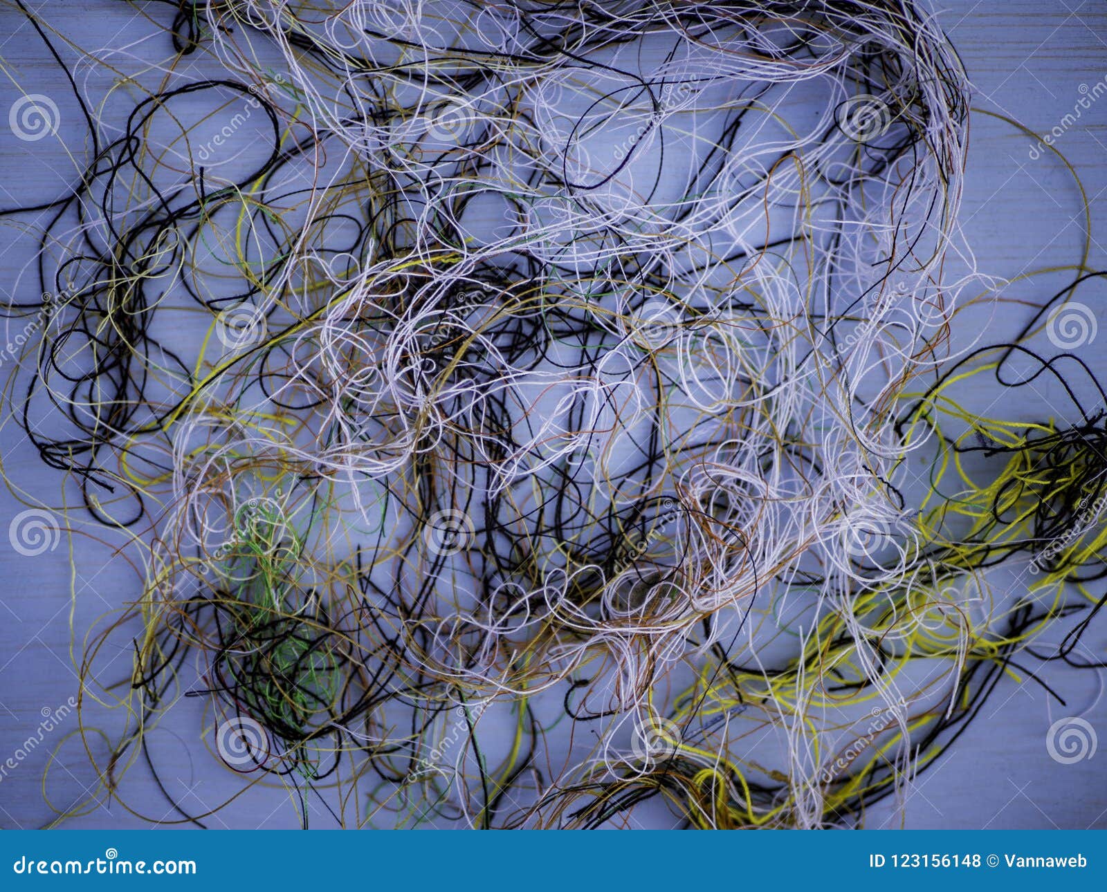 Sewing Thread Tangled Up in Multiple Colors on a Blue Table Stock Photo ...