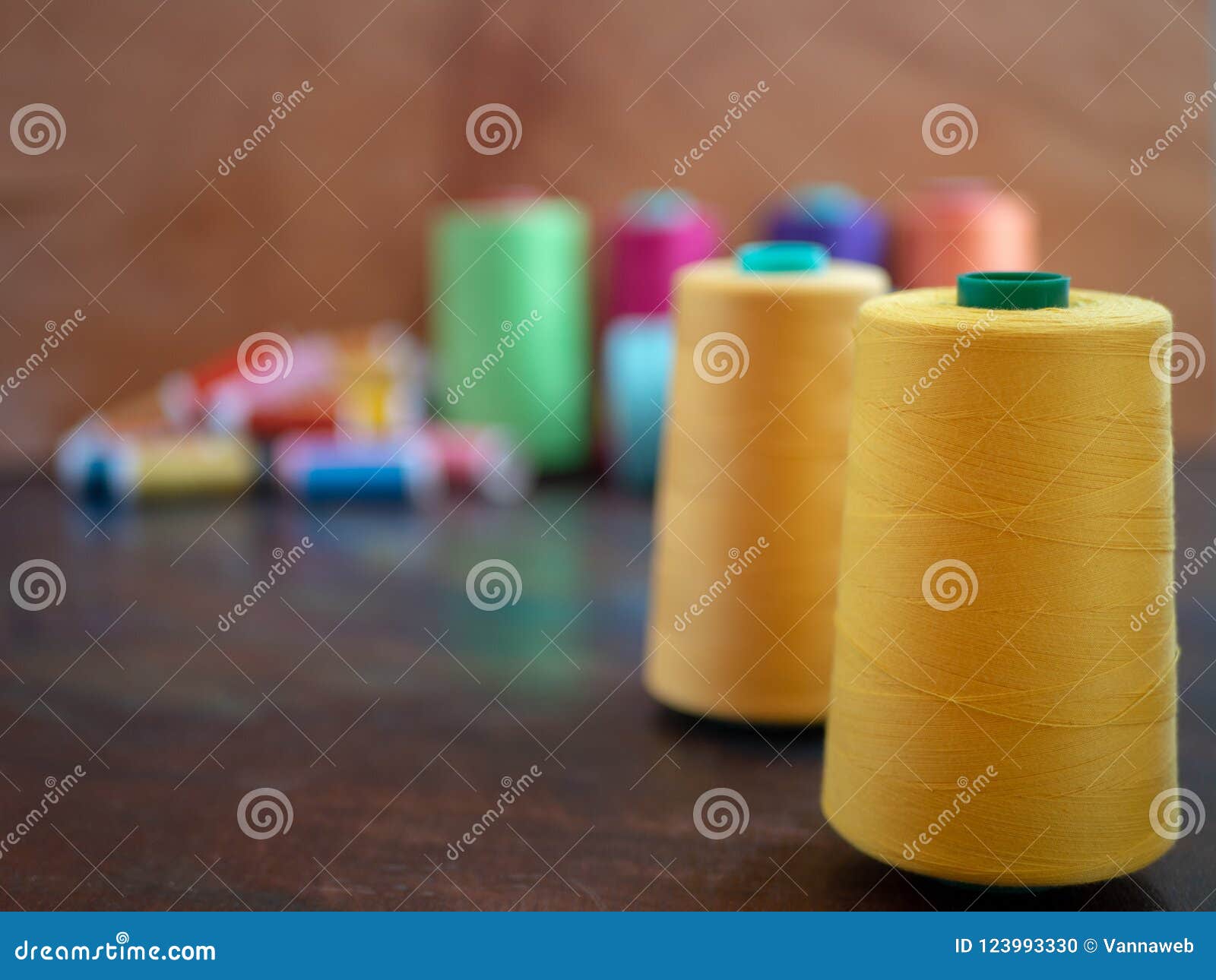 Sewing Threads in Many Colors on a Dark Table with Big Cones in Yellow ...