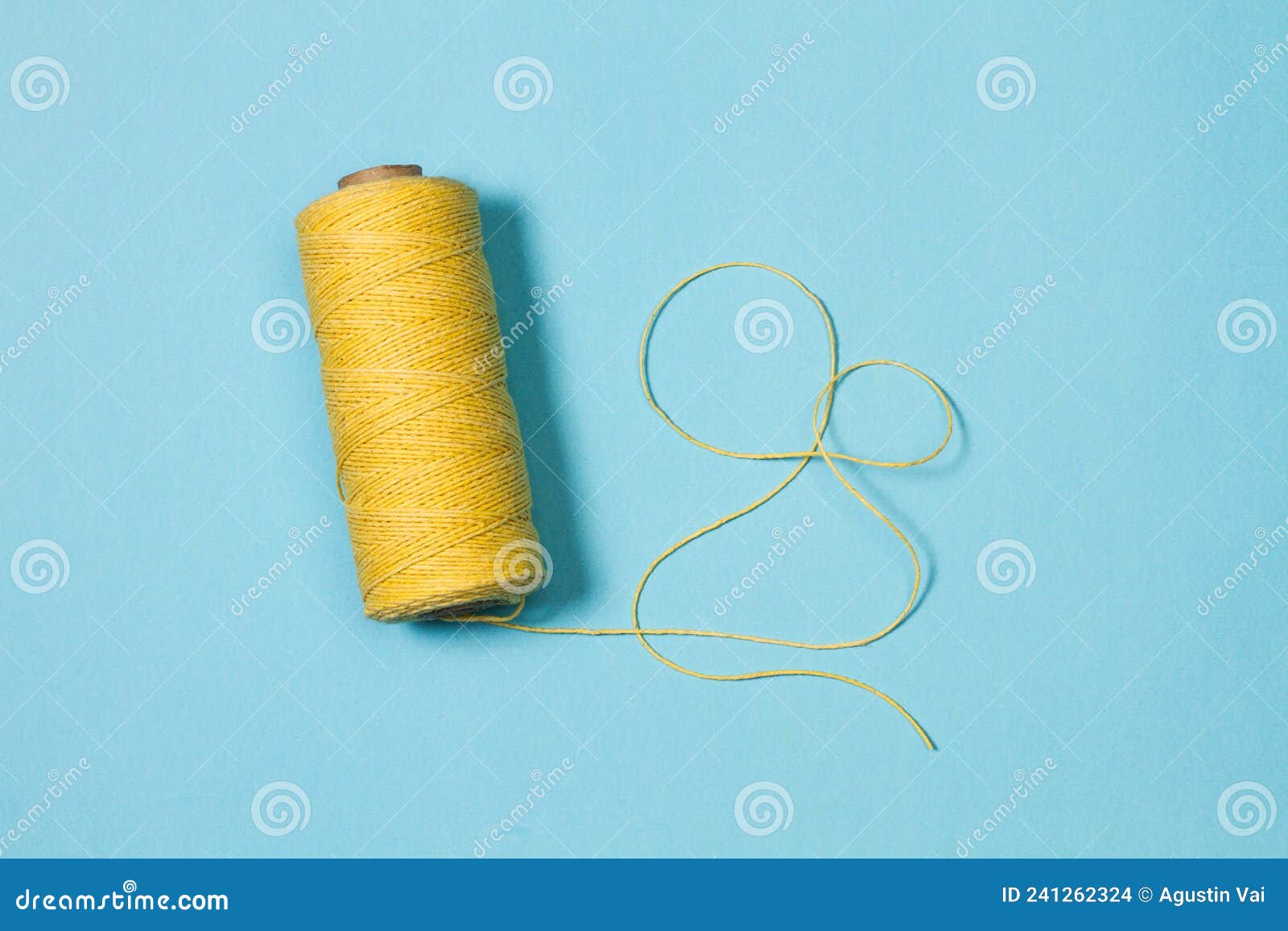 Sewing Yellow Thread Spool on a Light Blue Background Stock Photo ...