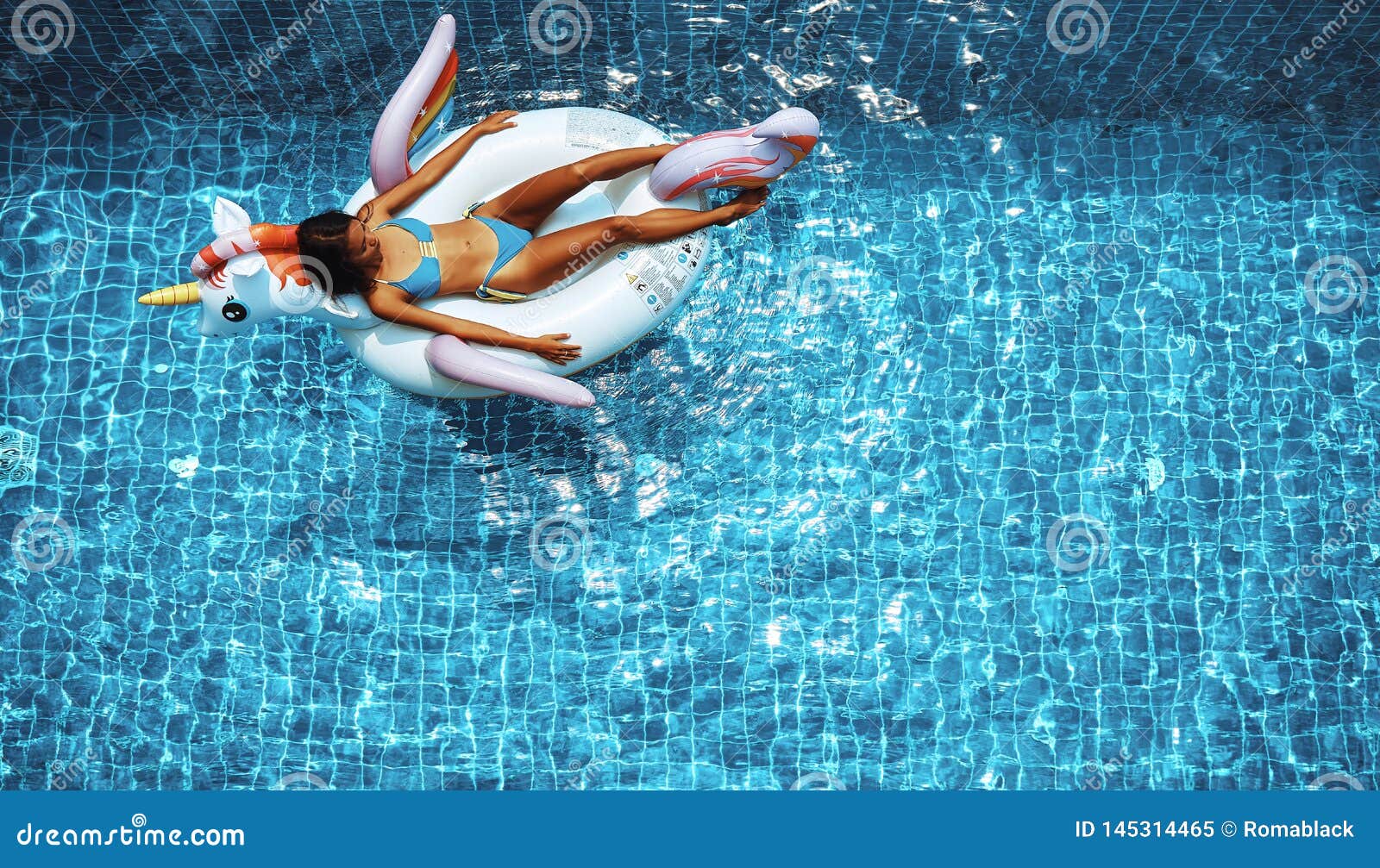 Asian Woman Wearing a Bikini and Relaxing on the Unicorn in a Swimming ... Asian Woman Wearing a Bikini and Relaxing on the Unicorn in a Swimming ...