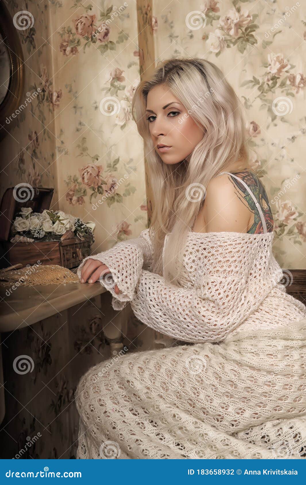Beautiful Blonde With A White Knitted Sweater Sits At A Table Stock