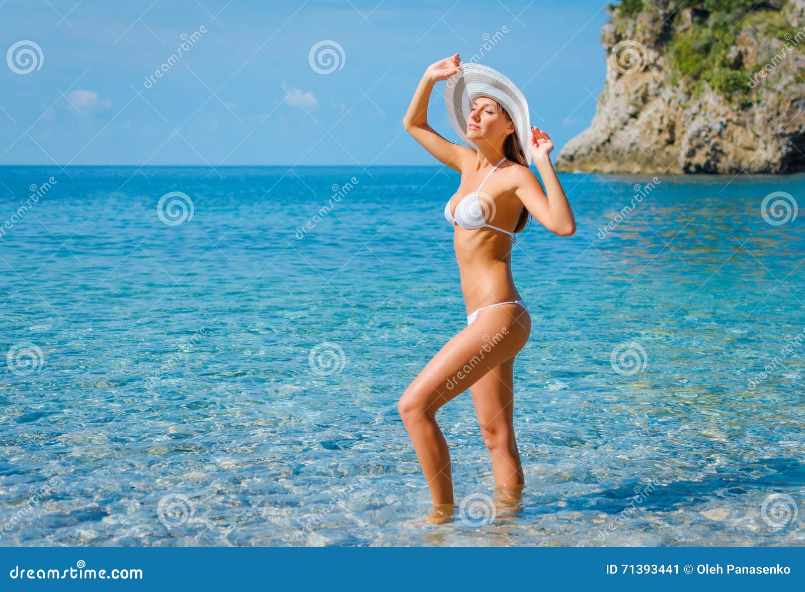 Beautiful Woman In White Bikini And Hat On Mediterranean Sea Coast