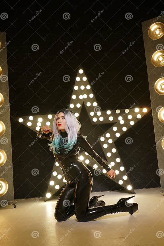Hot Slim Woman Posing In Latex Rubber Fashion Clothes On Black