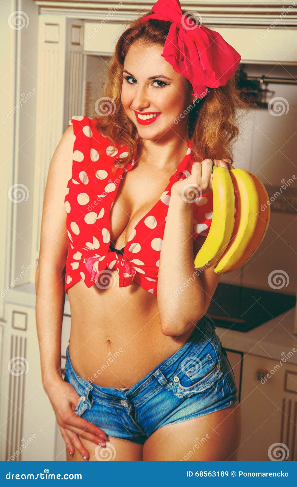 Lady In Pinup Style Posing With Bananas In The Kitchen Stock Image