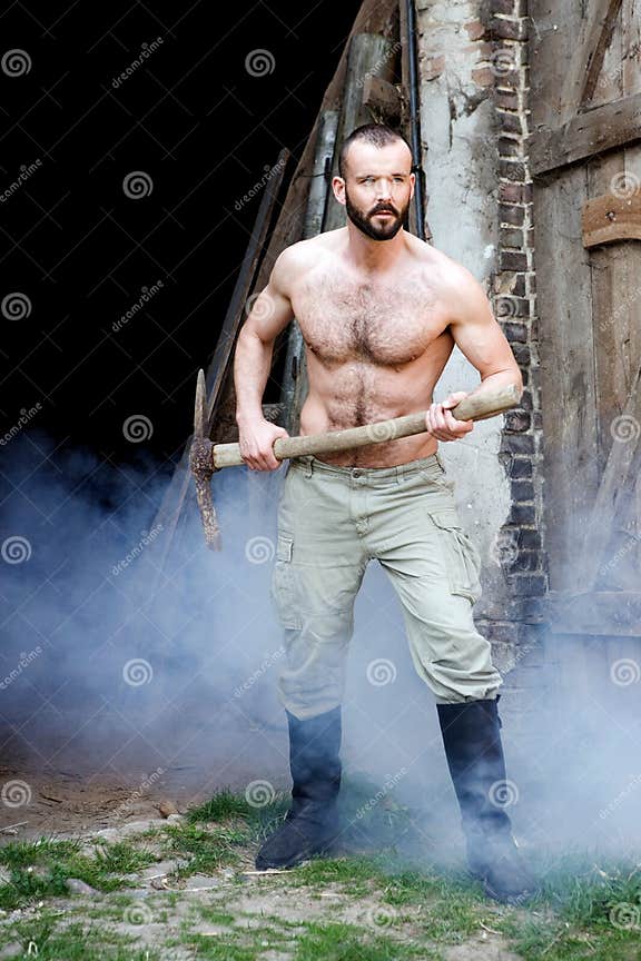 Shirtless Man Standing in Front of Barn with a Pickaxe Stock Image ...