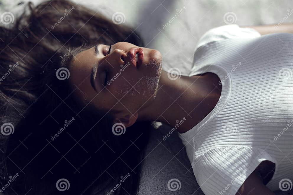 Tanned Brunette Girl With Closed Eyes And Big Sensual Lips Lying On