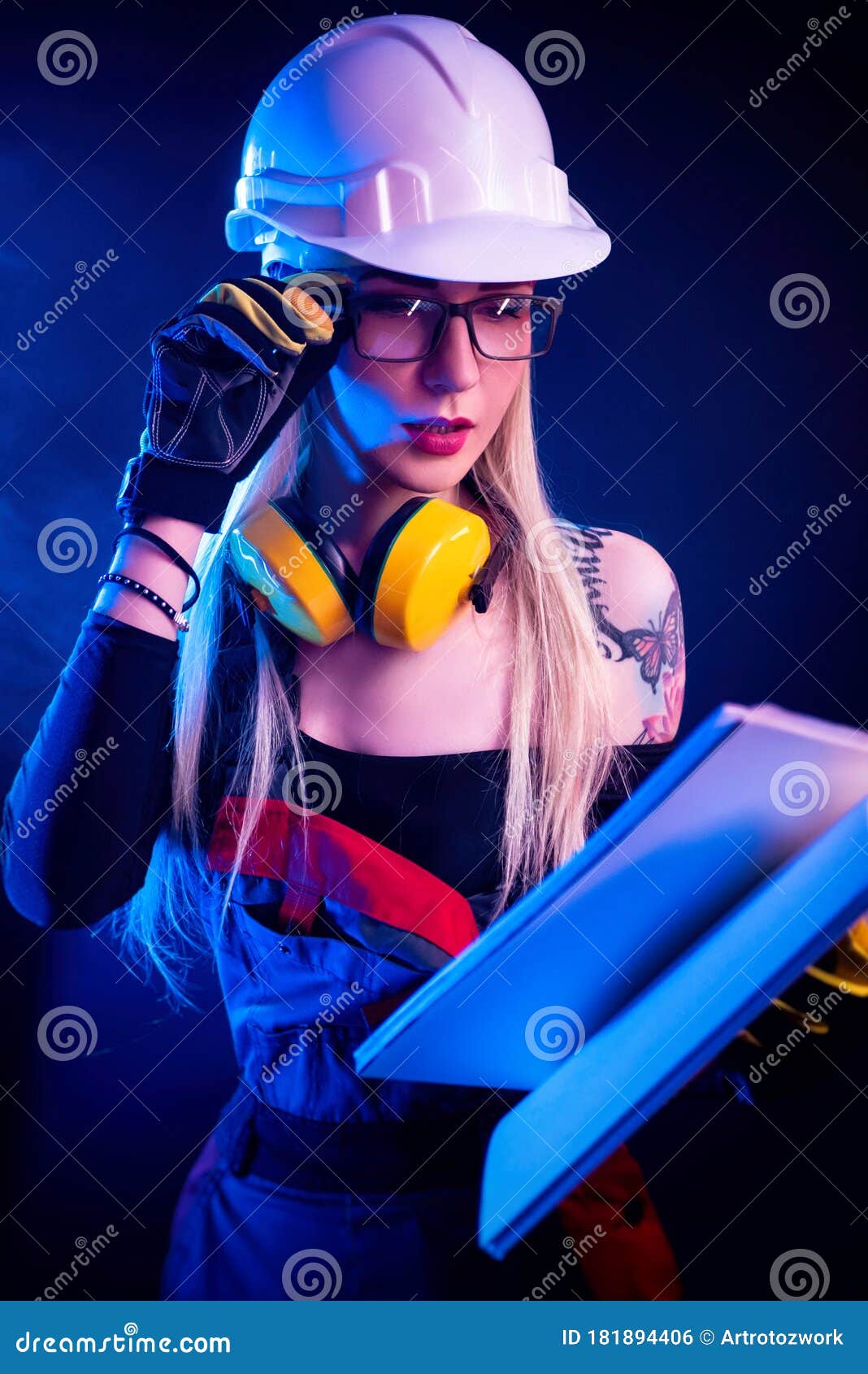 Woman Architect Holding Blueprints and Wearing a Helmet. in the Neon ... Woman Architect Holding Blueprints and Wearing a Helmet. in the Neon ...