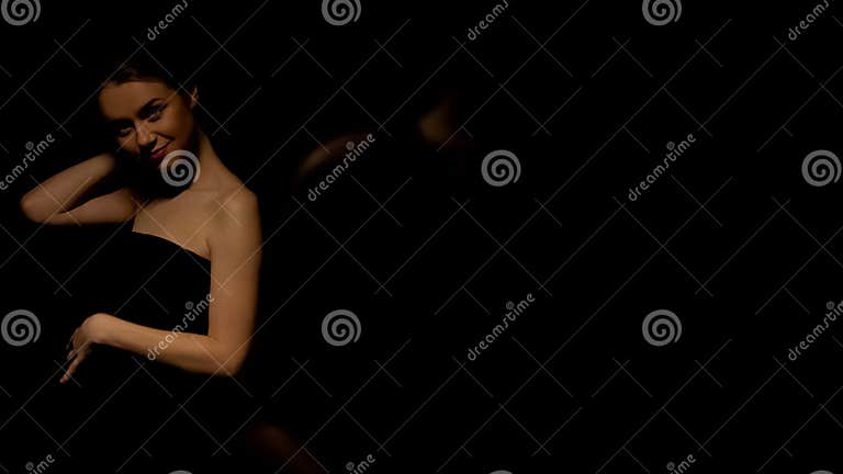Woman In Dress Posing For Camera Isolated On Black Background