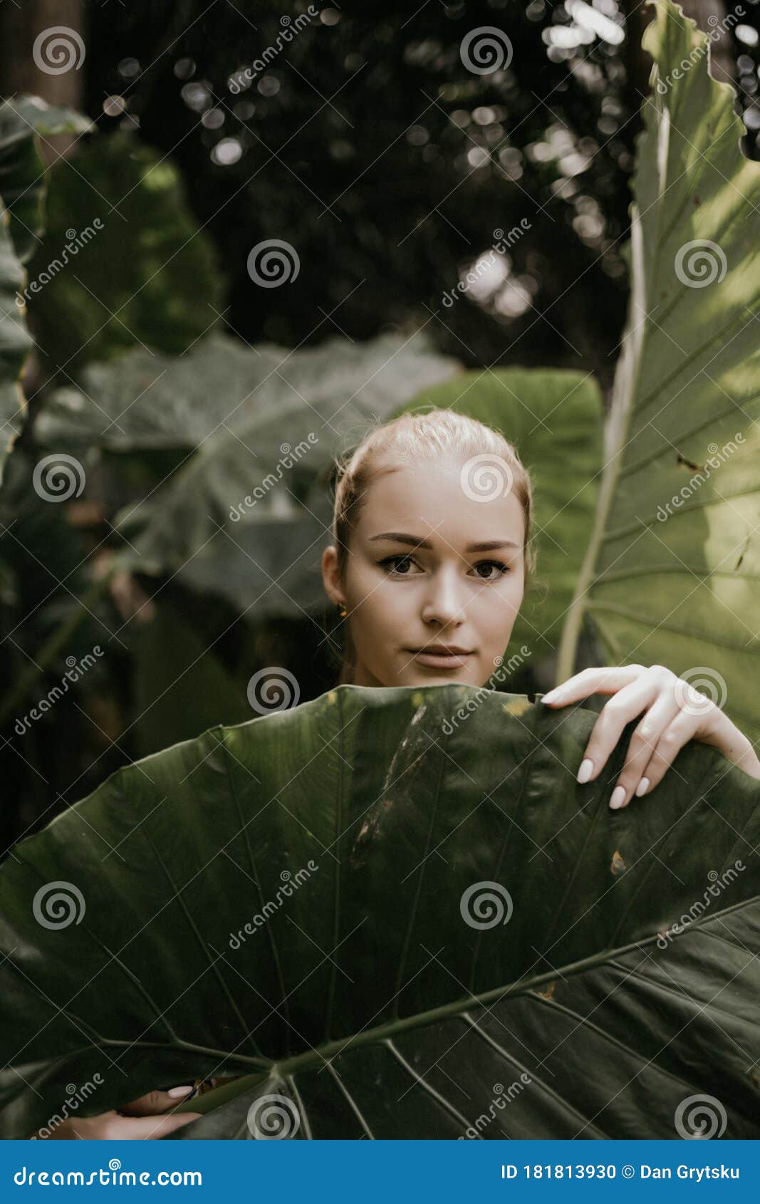 Beautiful Woman Hiding Behind The Palm Leaves In The In The Tropical
